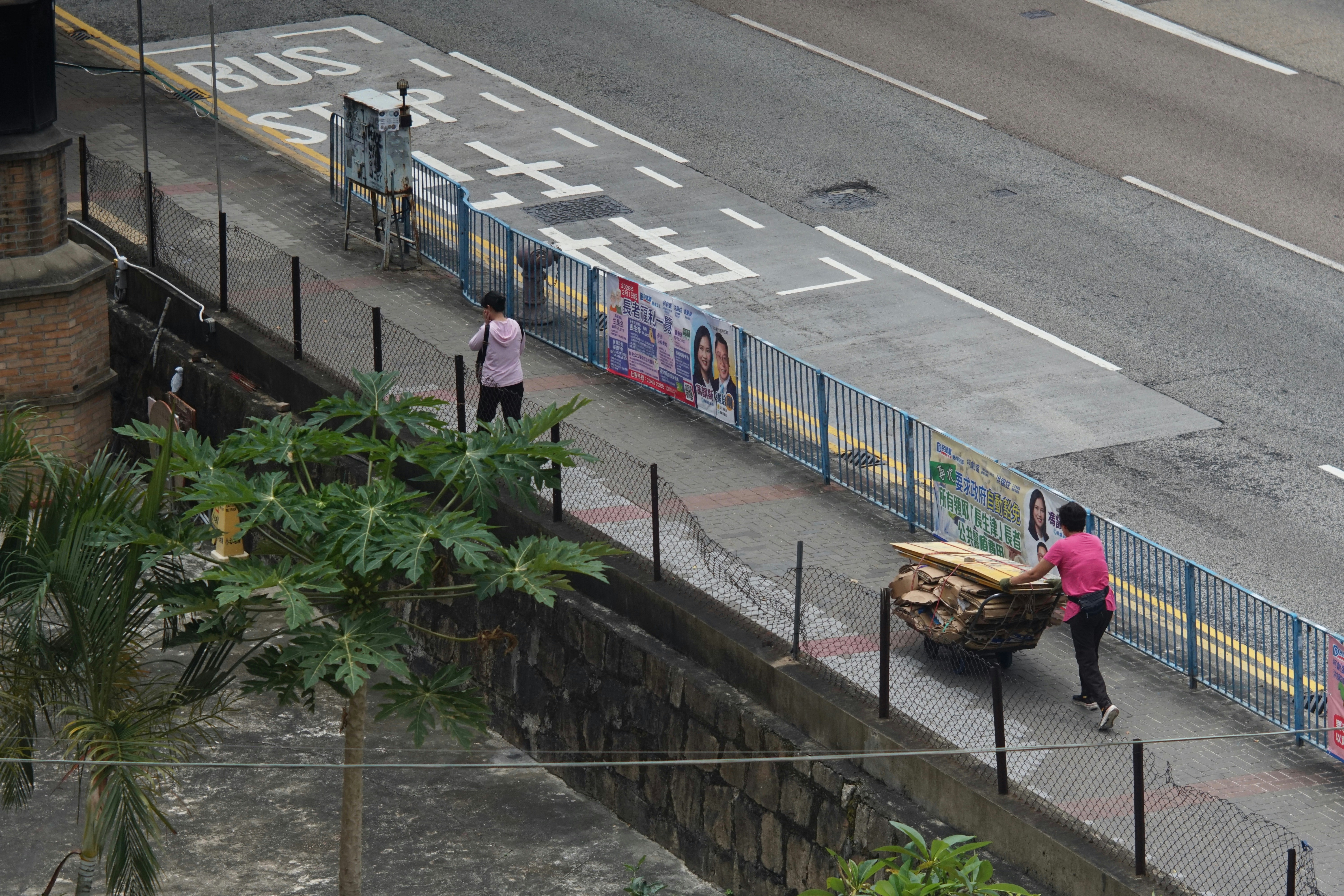 Street Corner Tug: A Worker and Pedestrian Amid a Sharp City Verge