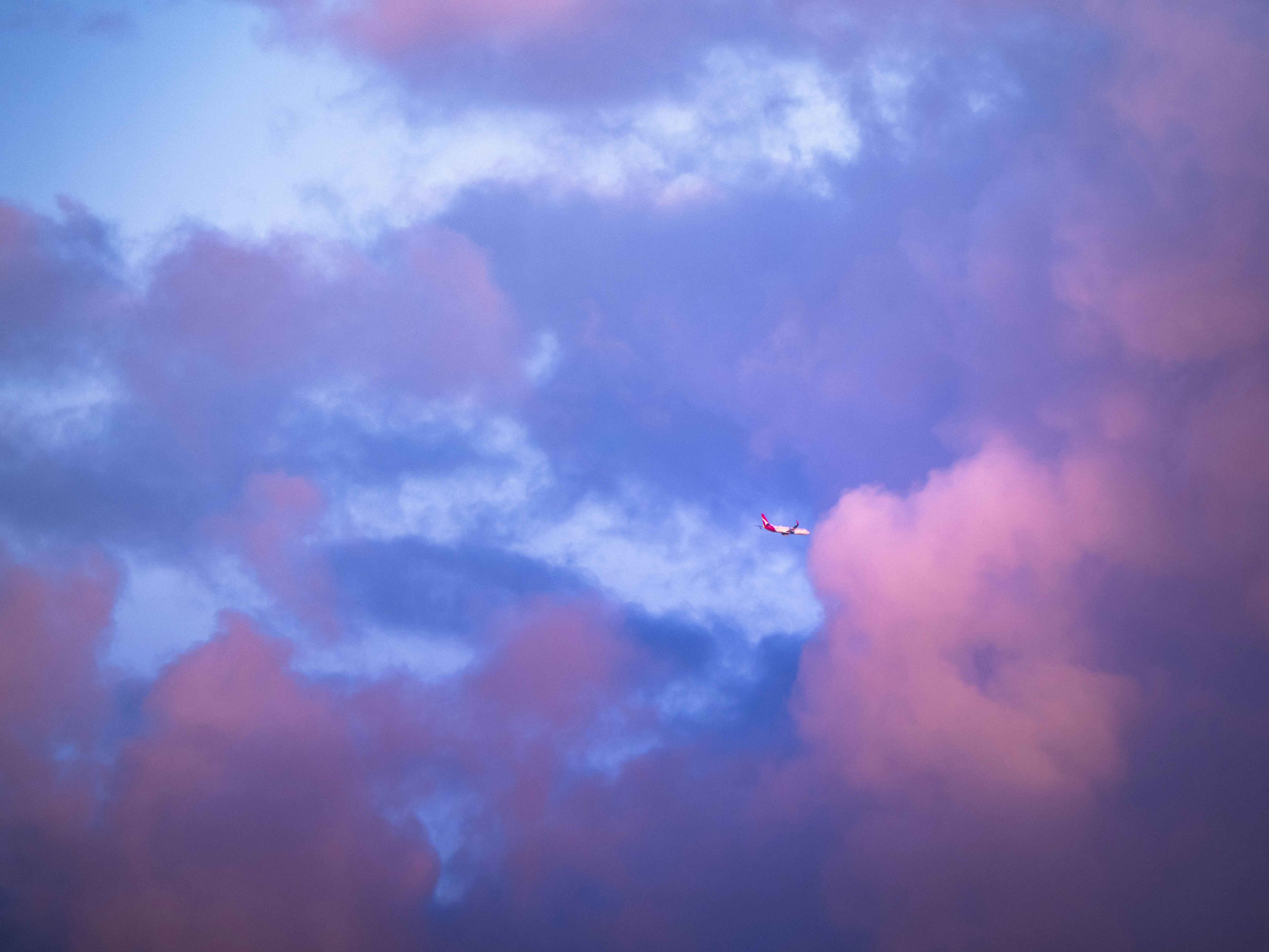 Little Airliner Through Pink Clouds at Dusk
