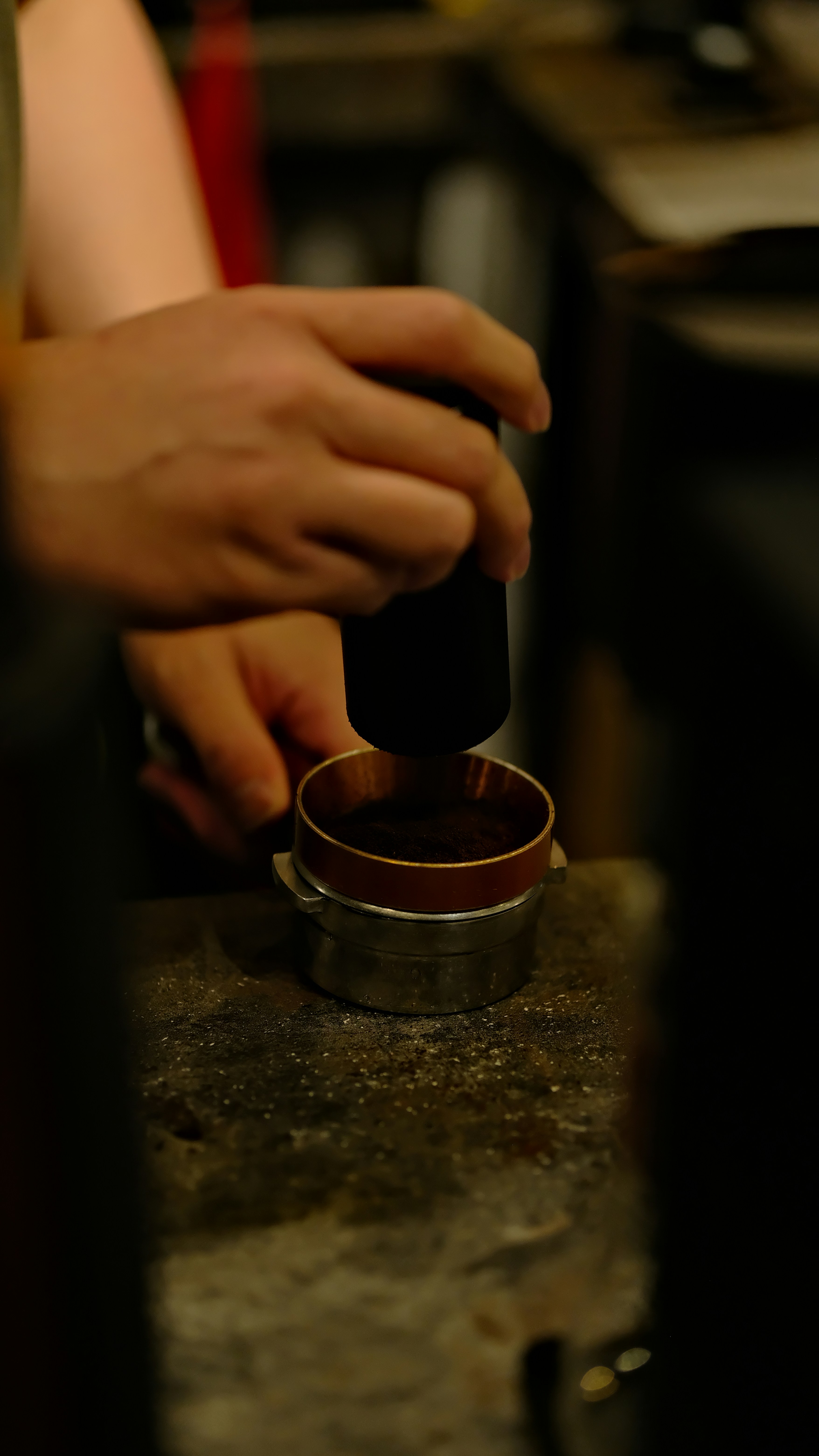 Precise Craft: Hand, Tool, and Ground Coffee in Focus