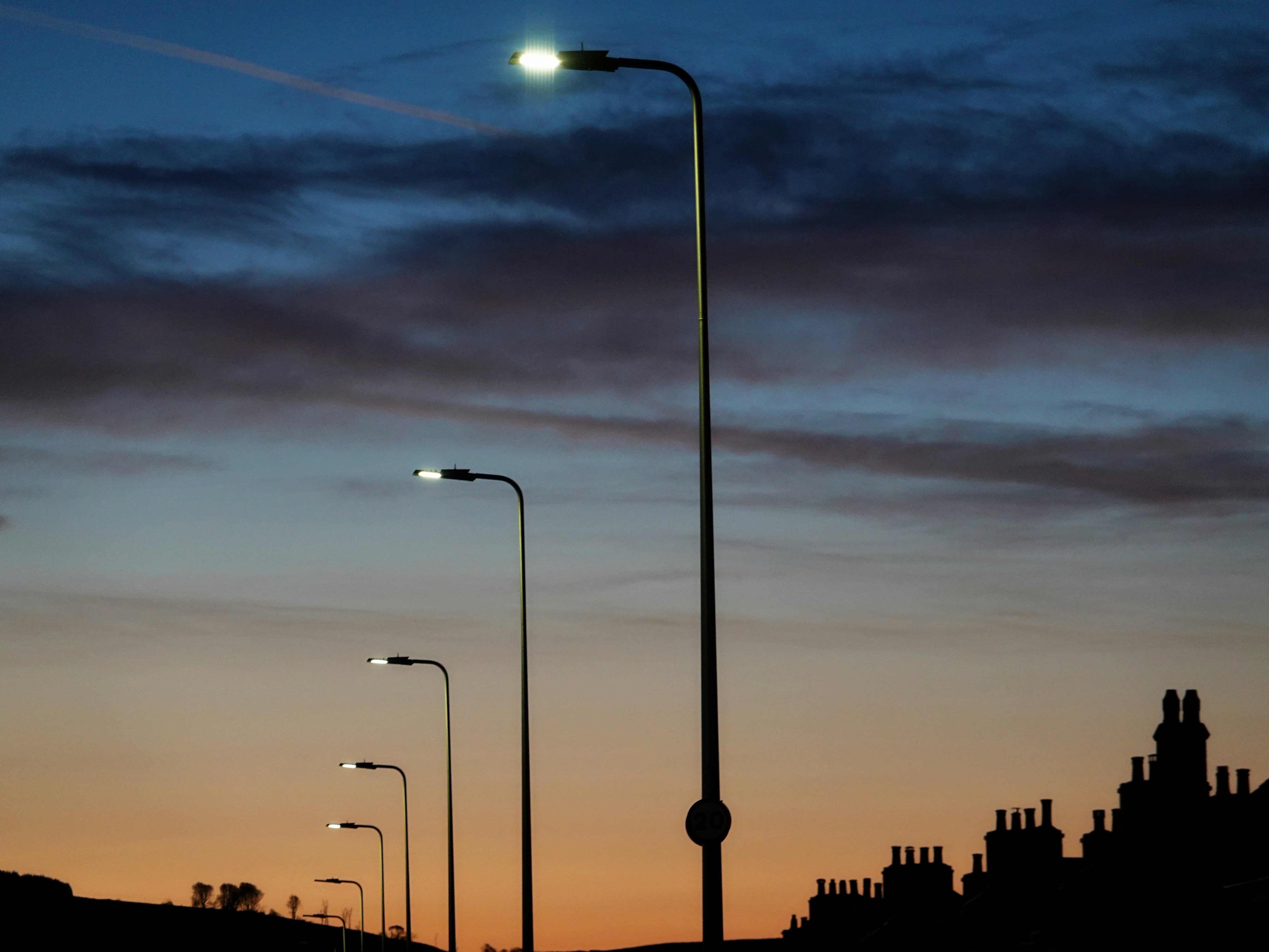 Evening streetlight silhouettes: a calm descent into dusk