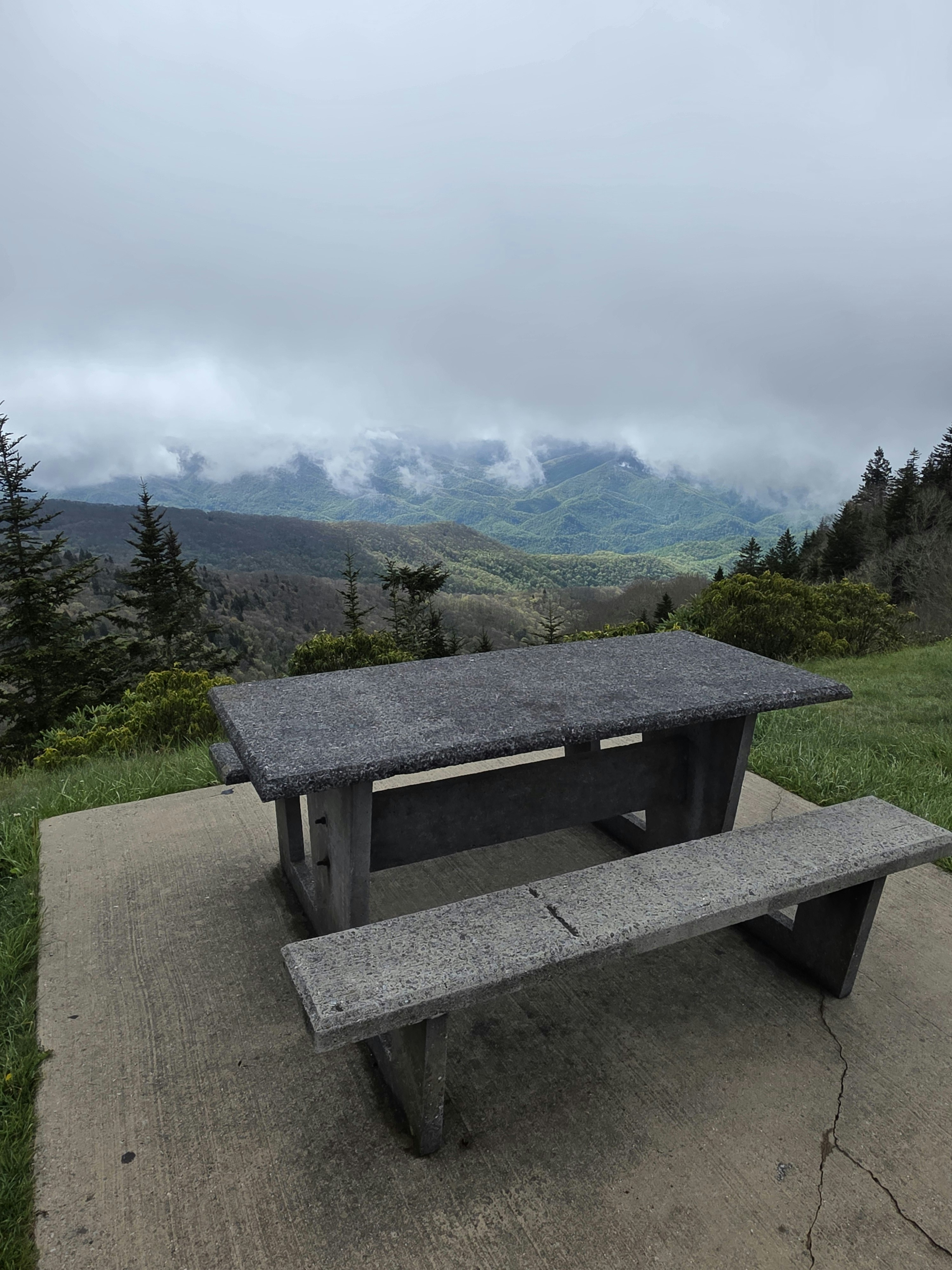 Quiet Overlook: A Concrete Table Framed by Misty Mountains