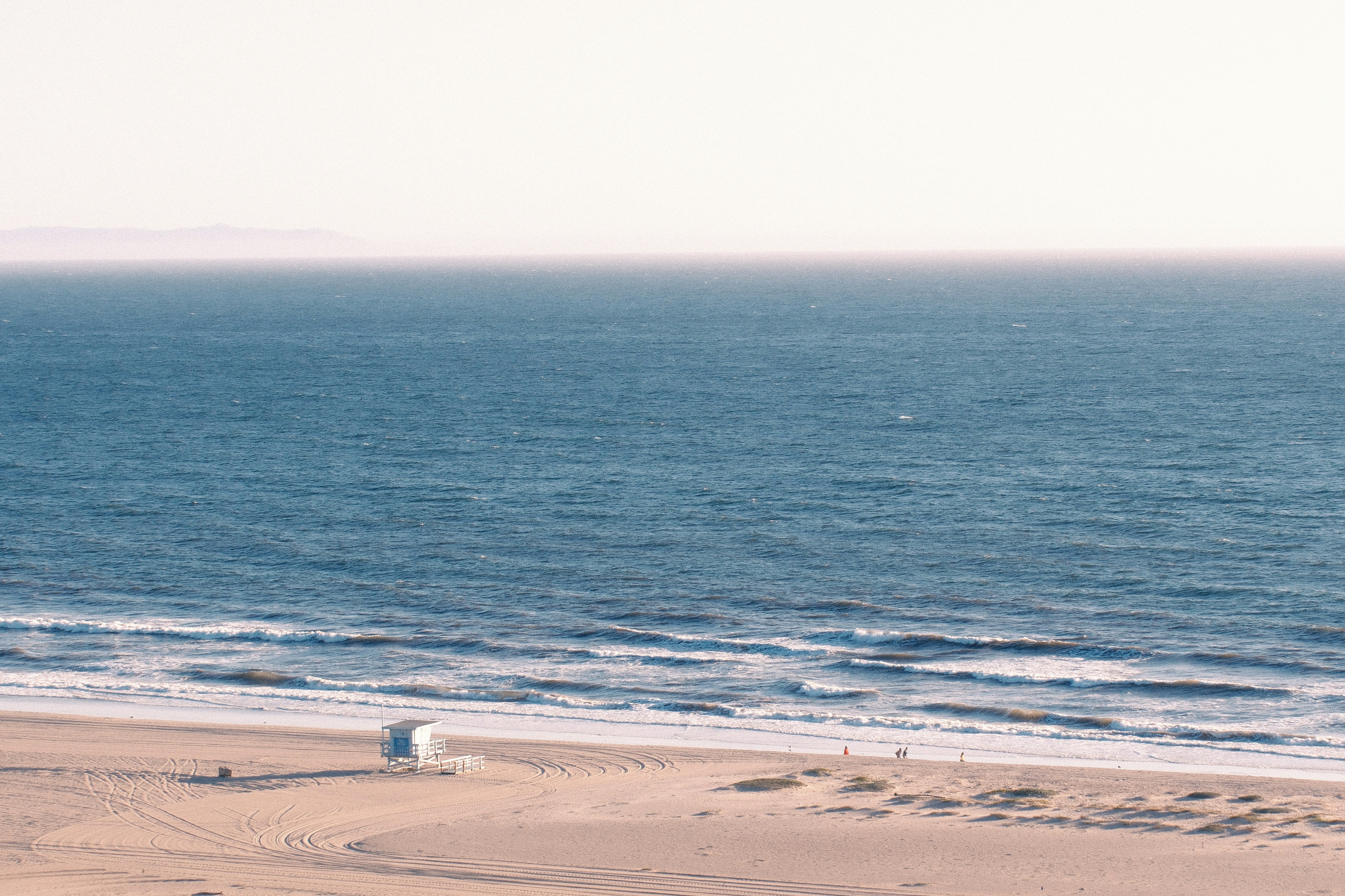 Quiet Offshore Vista: Sand, Sea, and a Distant Lifeguard Hut