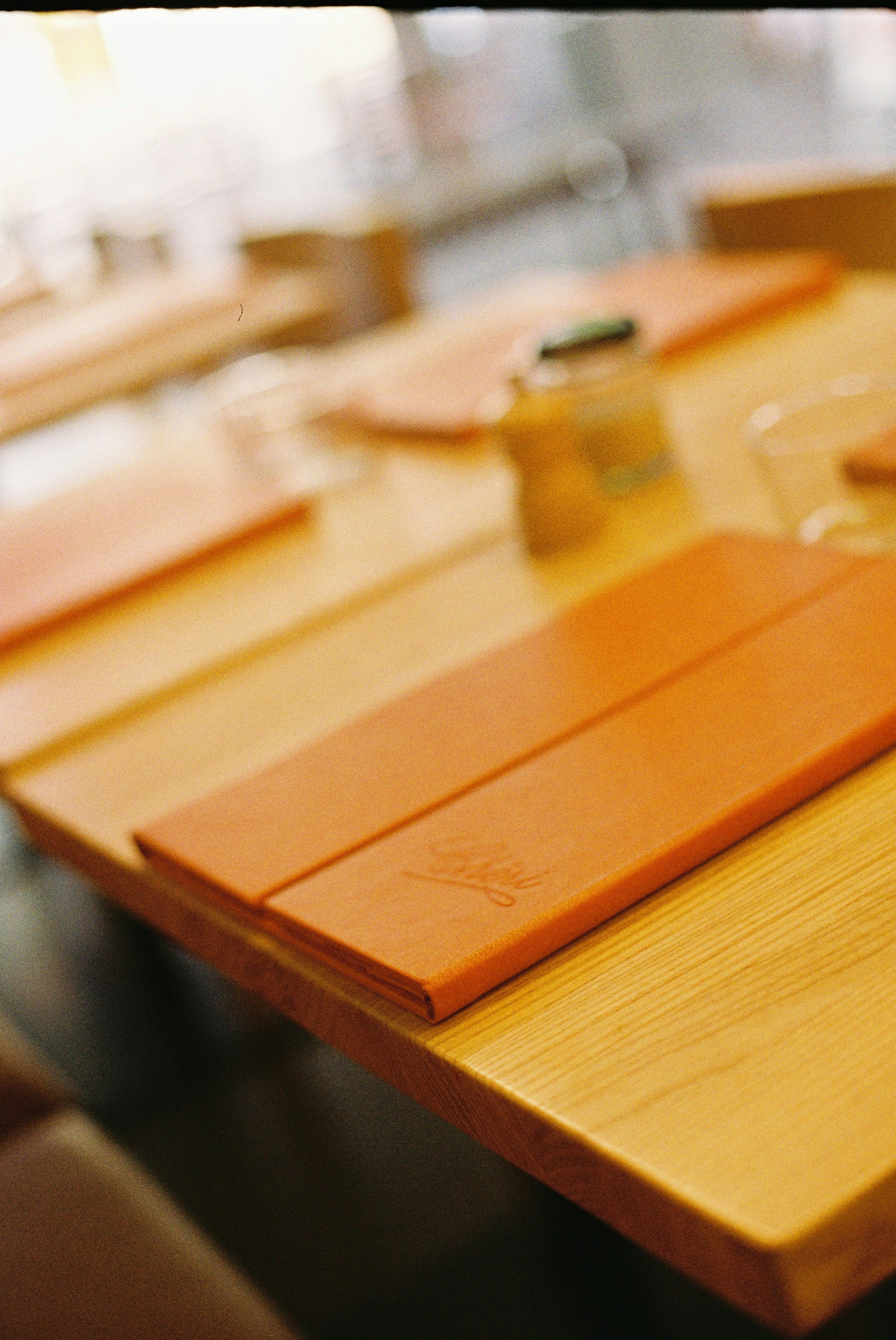 Leather-bound Menu Gliding Across a Sunlit Café Table