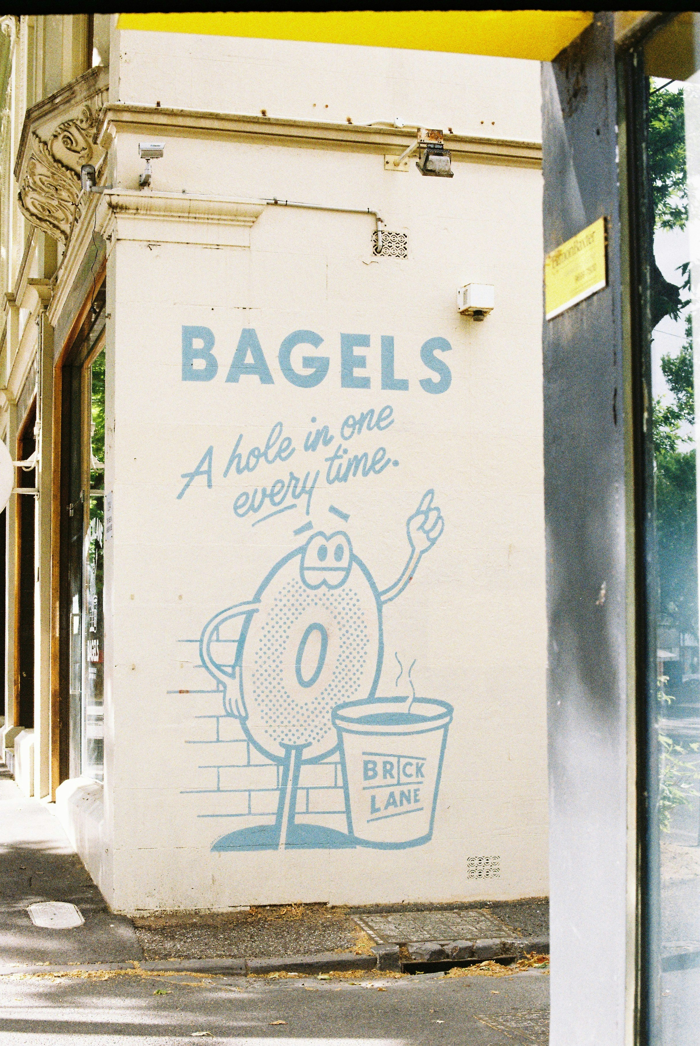 Bagel Mascot Salutes the Street Corner