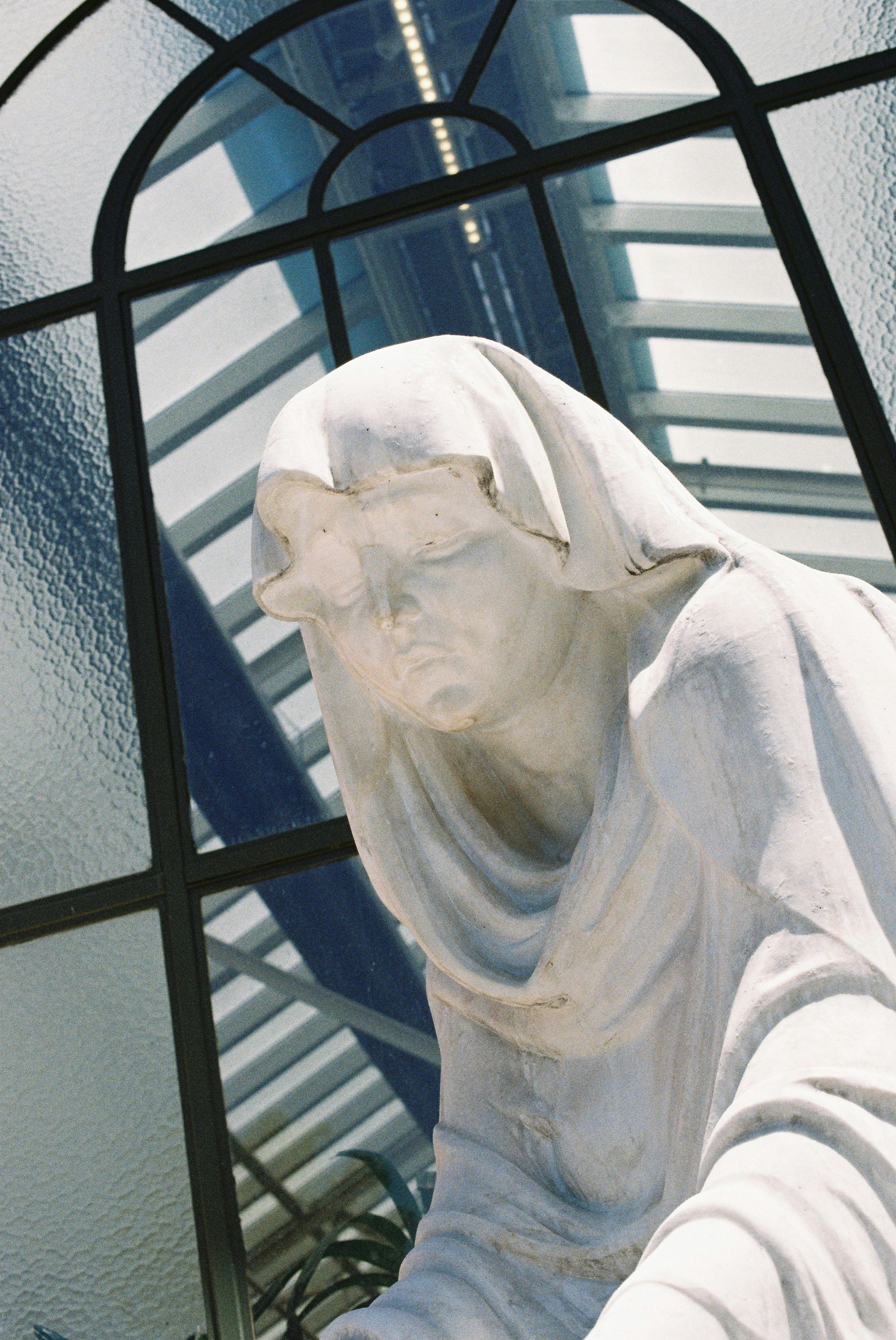 Sculpted Sentinel Within Glass Arches