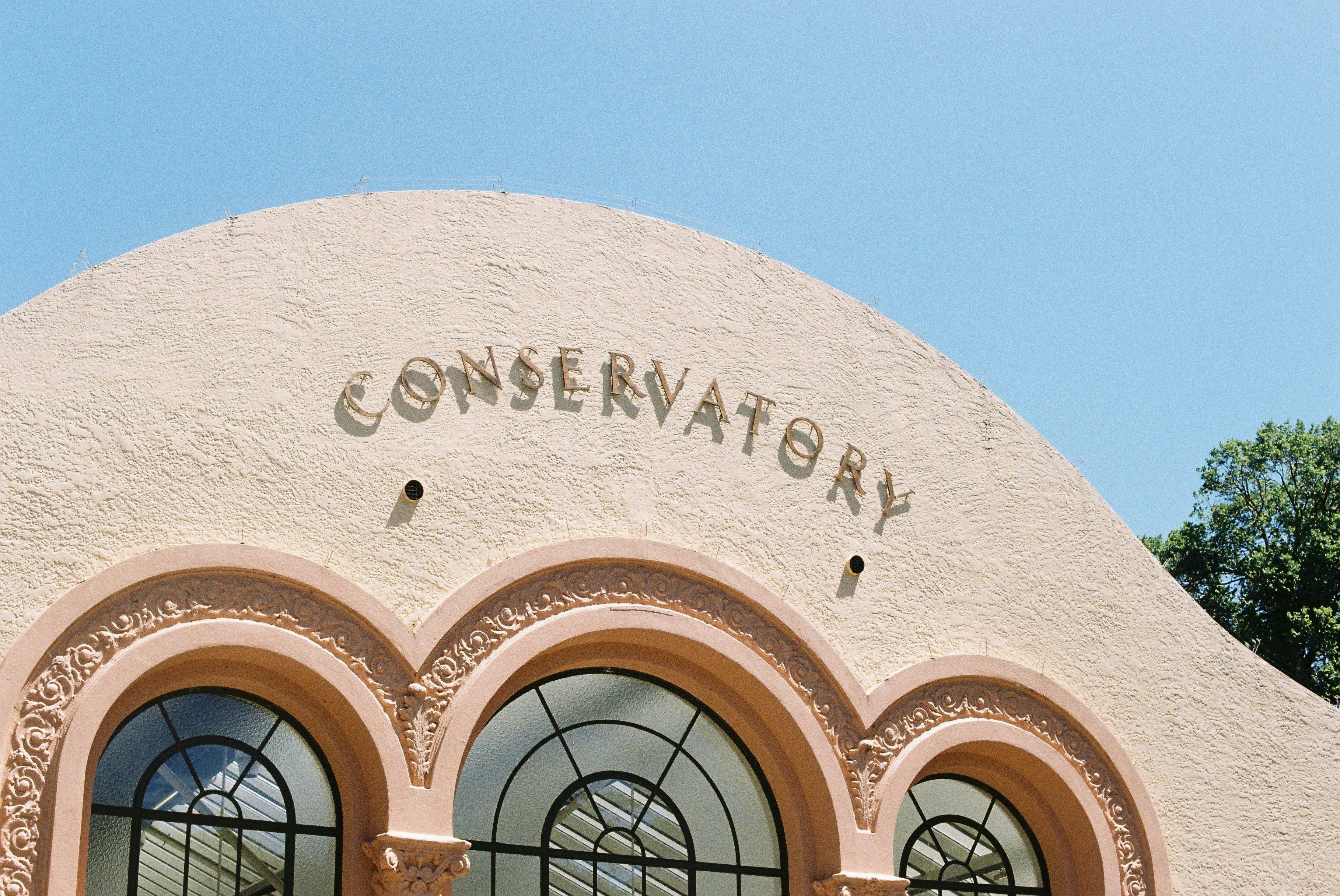 Conservatory Facade: Arched Windows and Soft Sandstone Detail