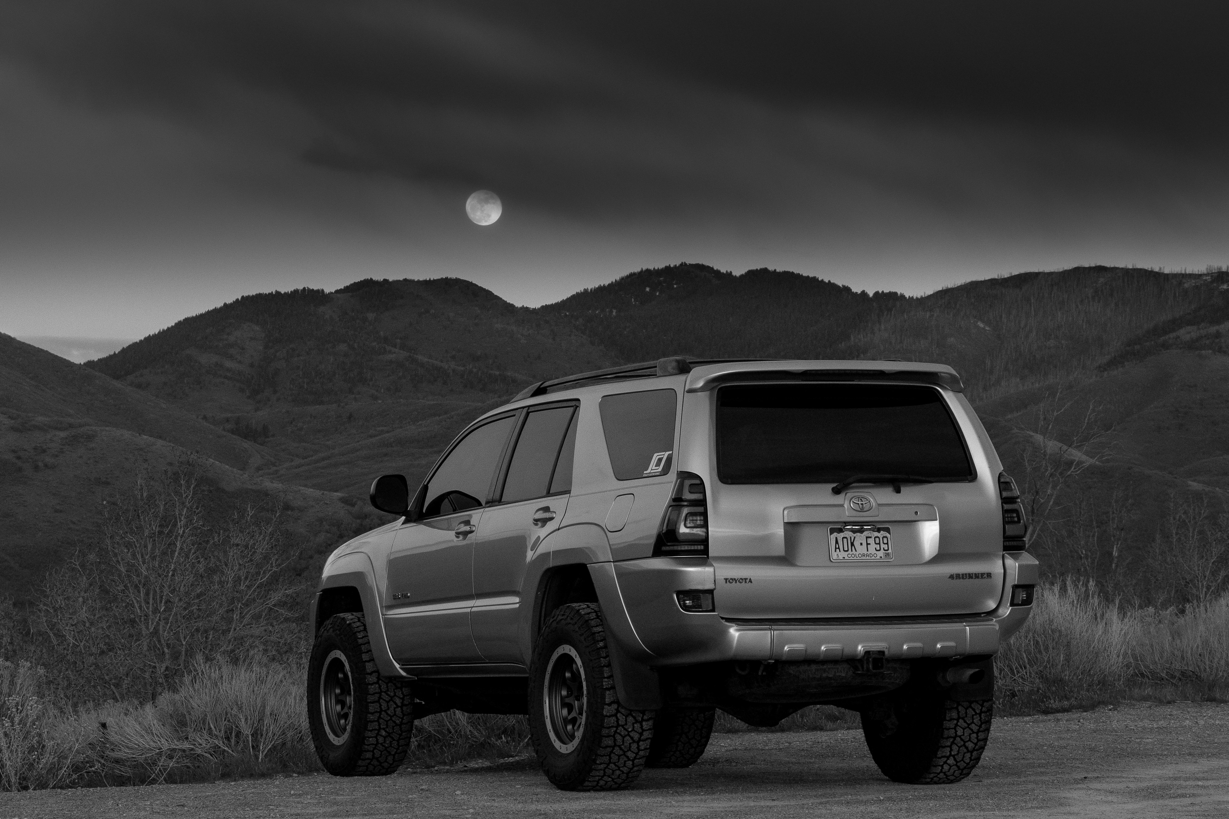 Moonlit Parking: An SUV Backed by Desert Dunes