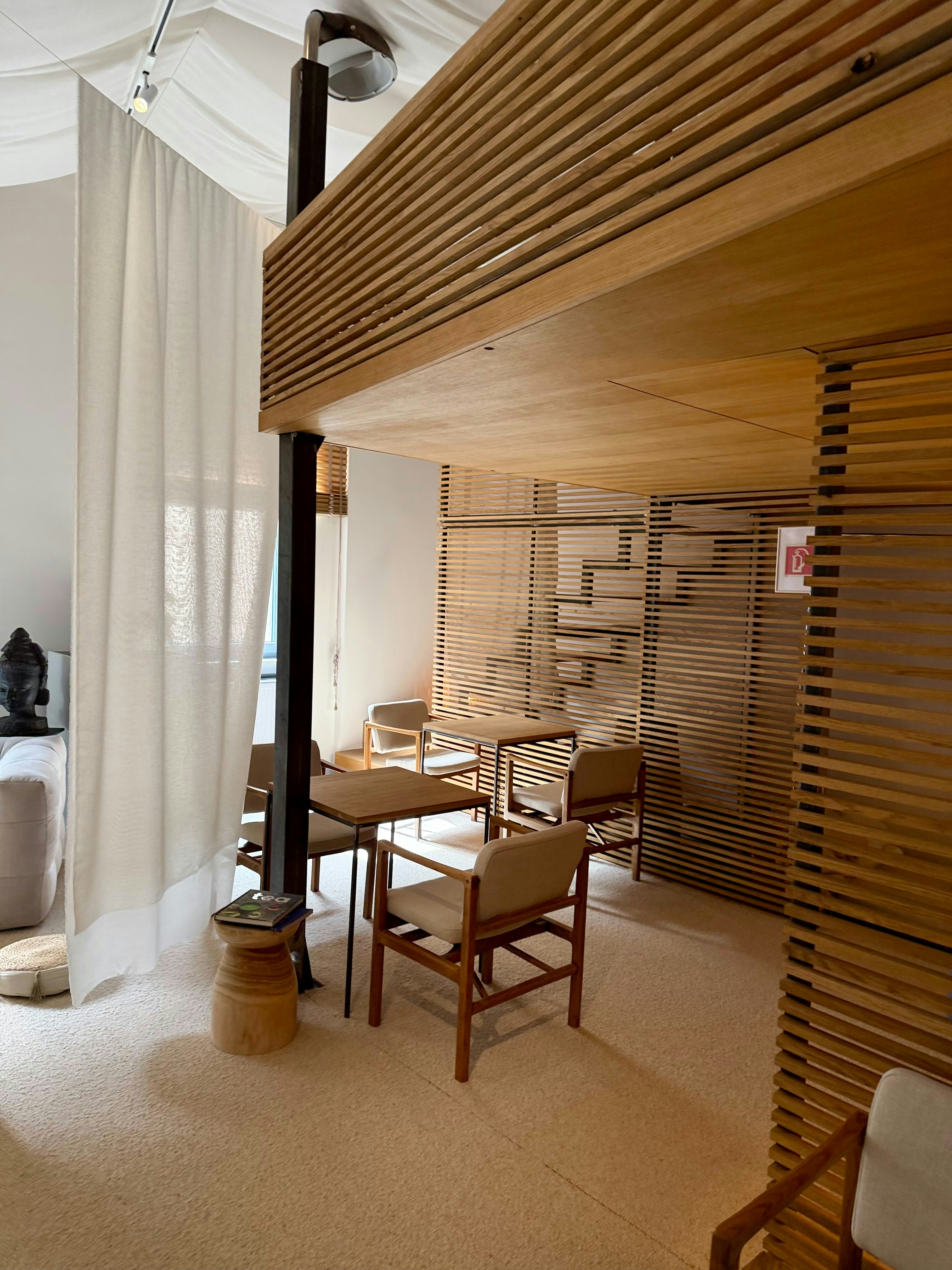 Warm Parquet and Slatted Privacy: A Quiet Café Nook Under a Loft Bed
