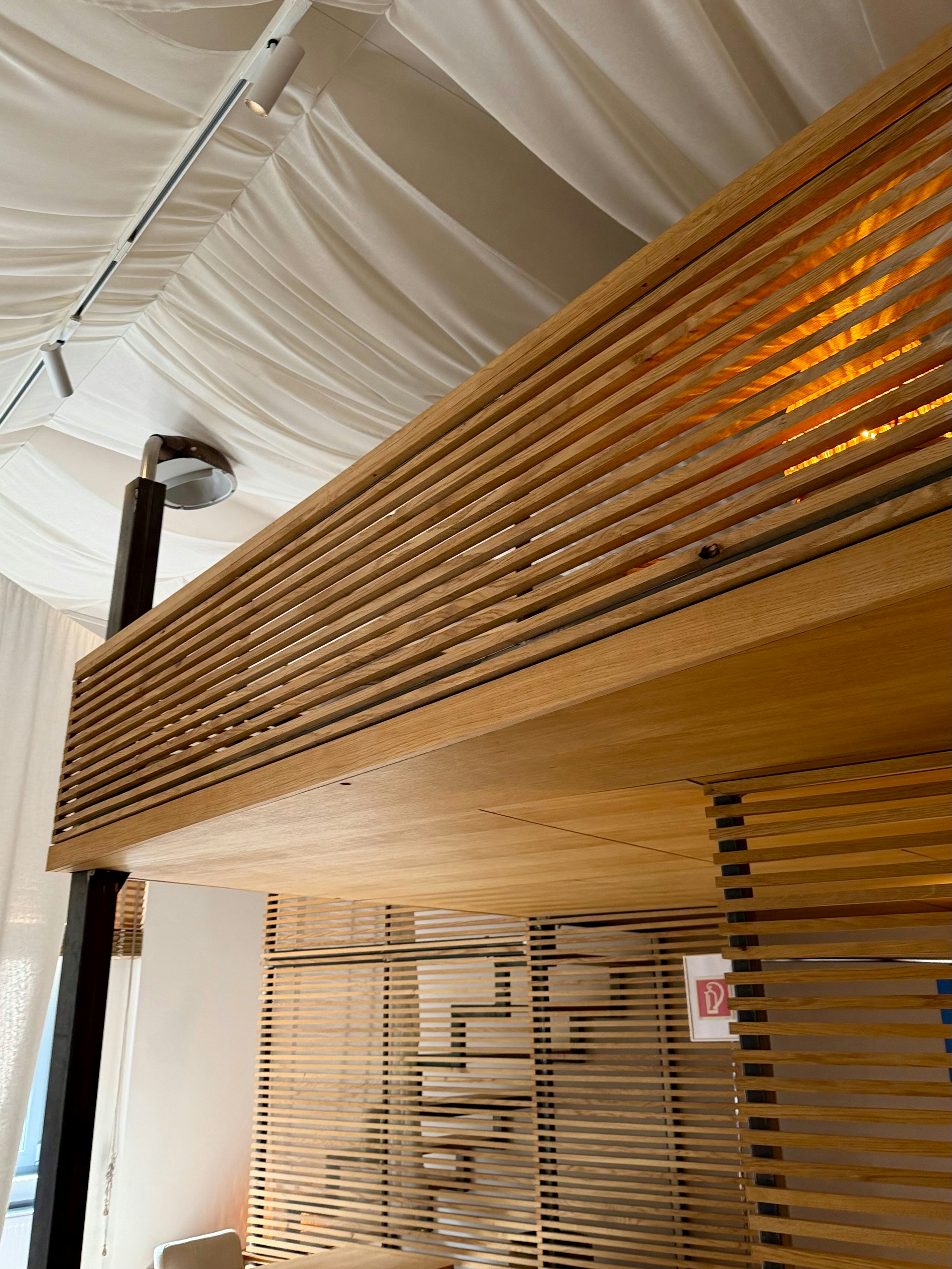 Layered Warmth: Wooden Slats and Soft Drapery Create an Elevated Interior Scene