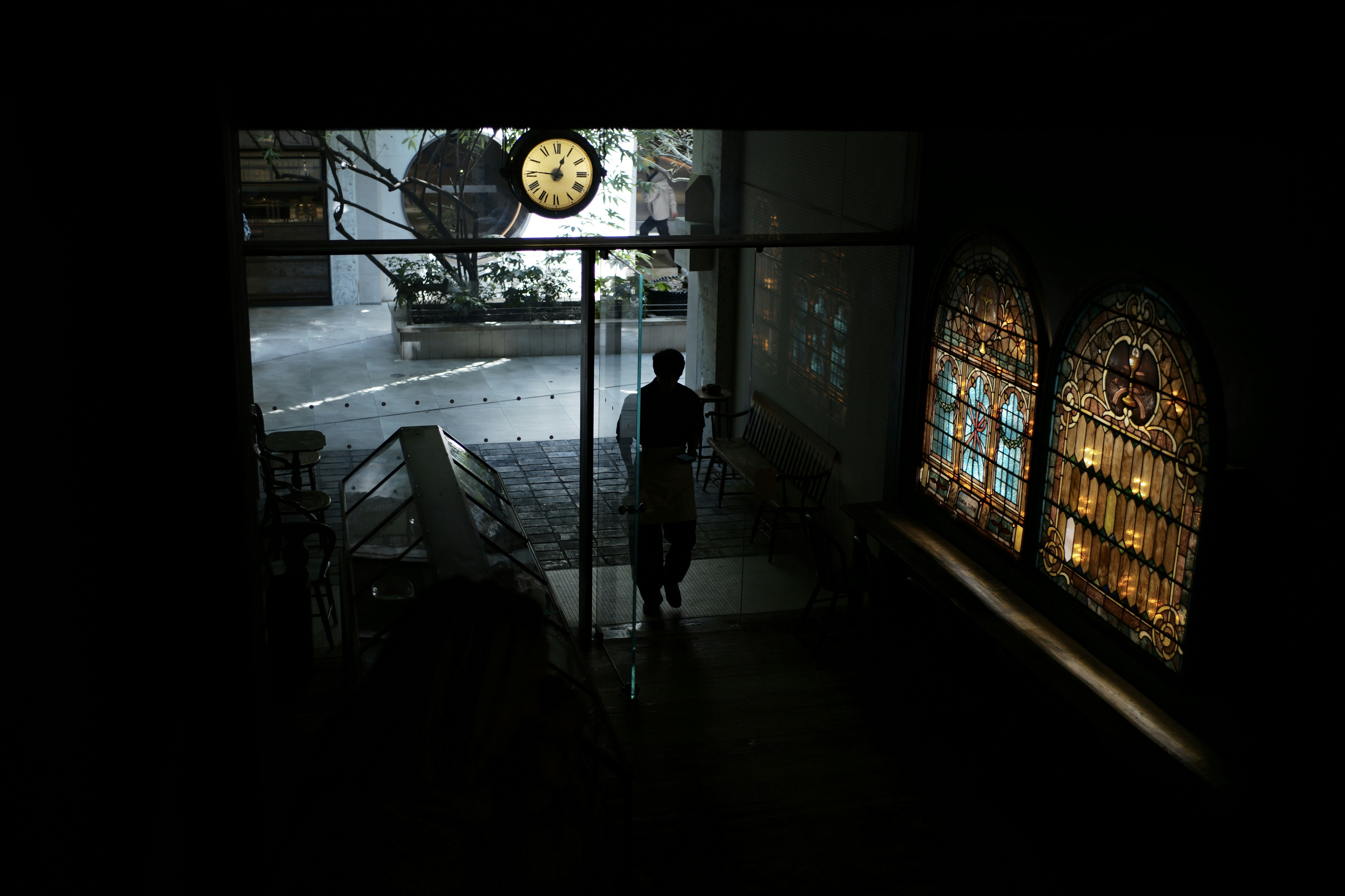 Silhouette at the Threshold: Clock, Glass, and Passage