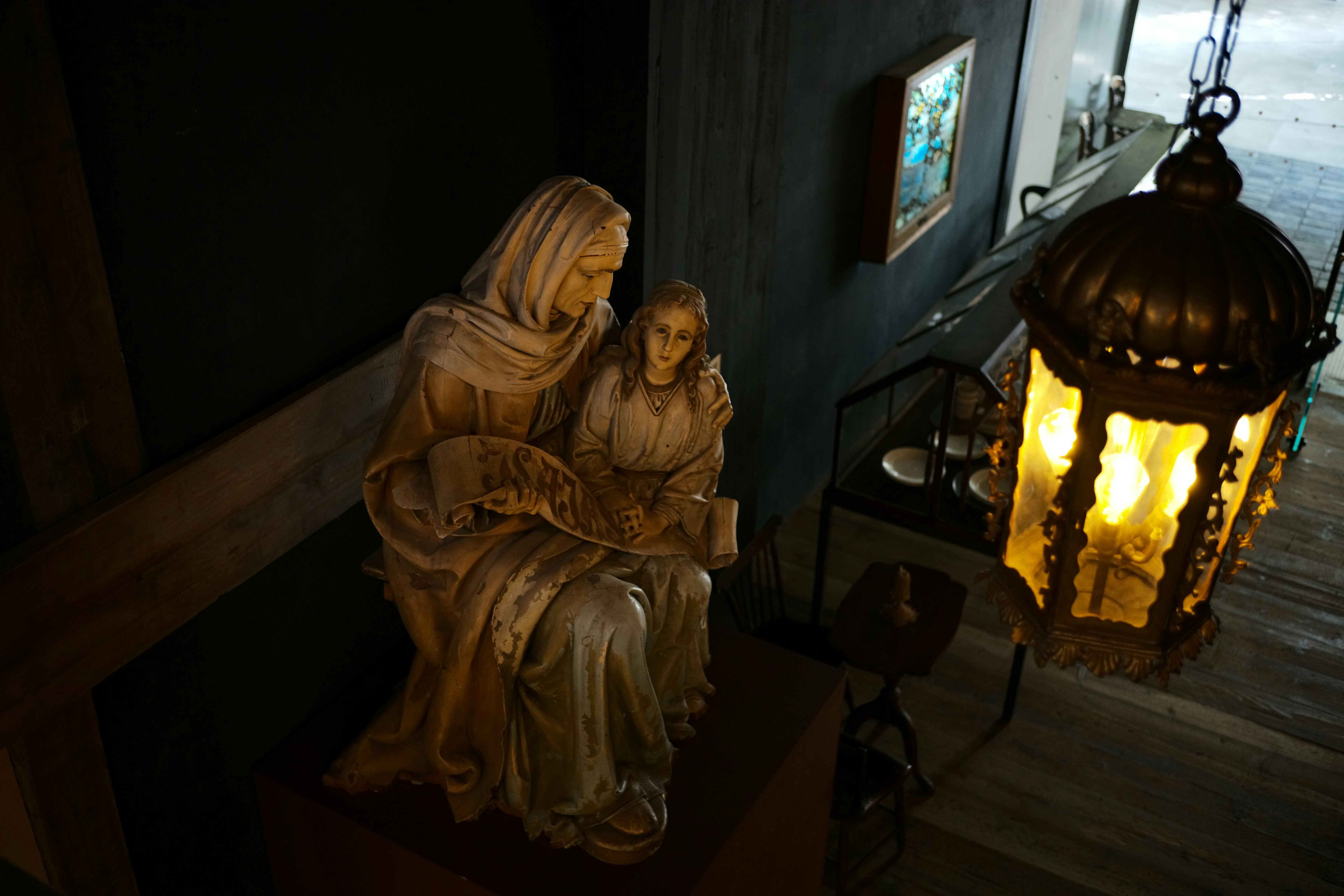 Soft Light on a Sacred Pair: A Quiet Shrine Figure Bathed in Warm Lantern Glow