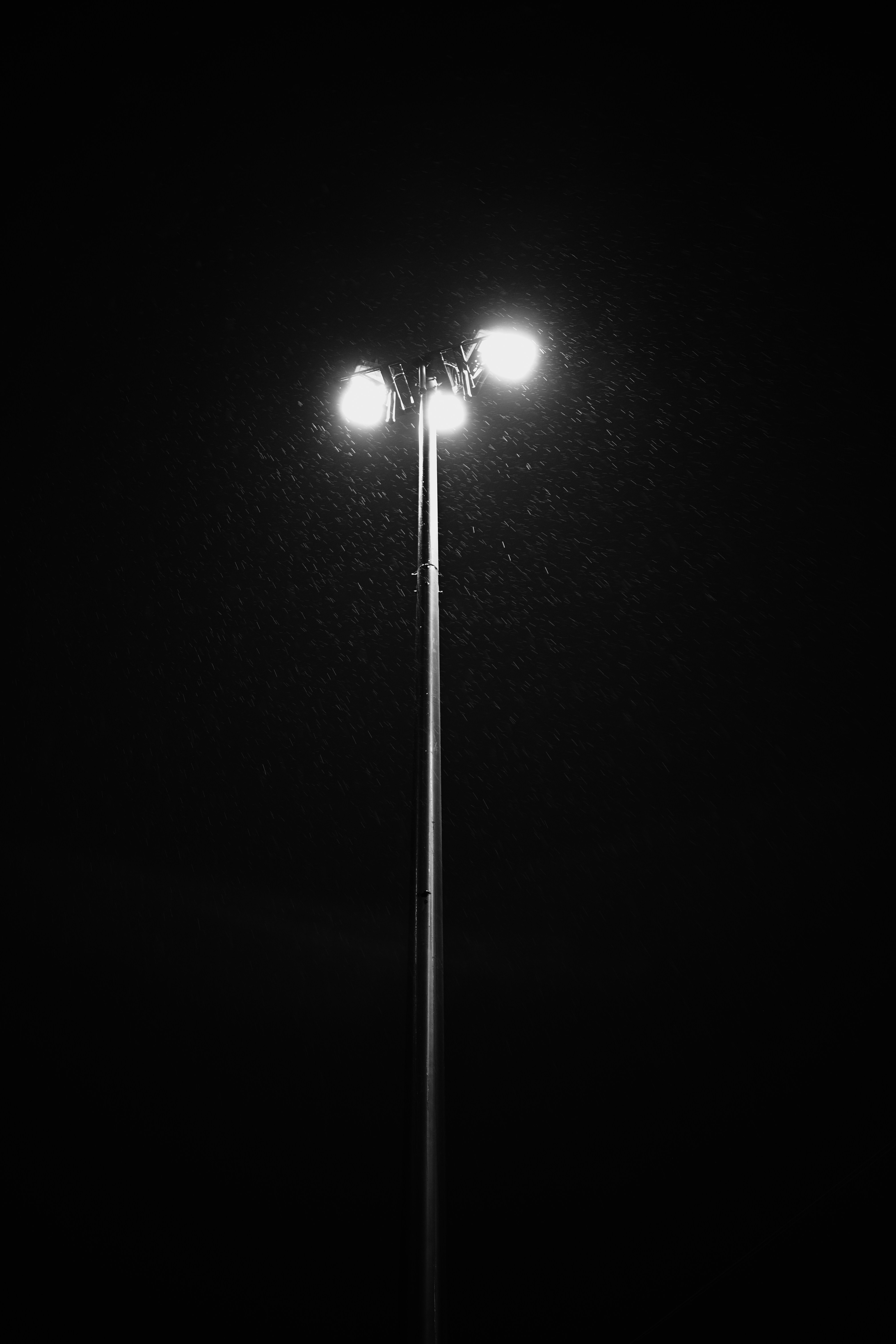 Beacon in the Night: A Lone Streetlamp Sprinkles Snow