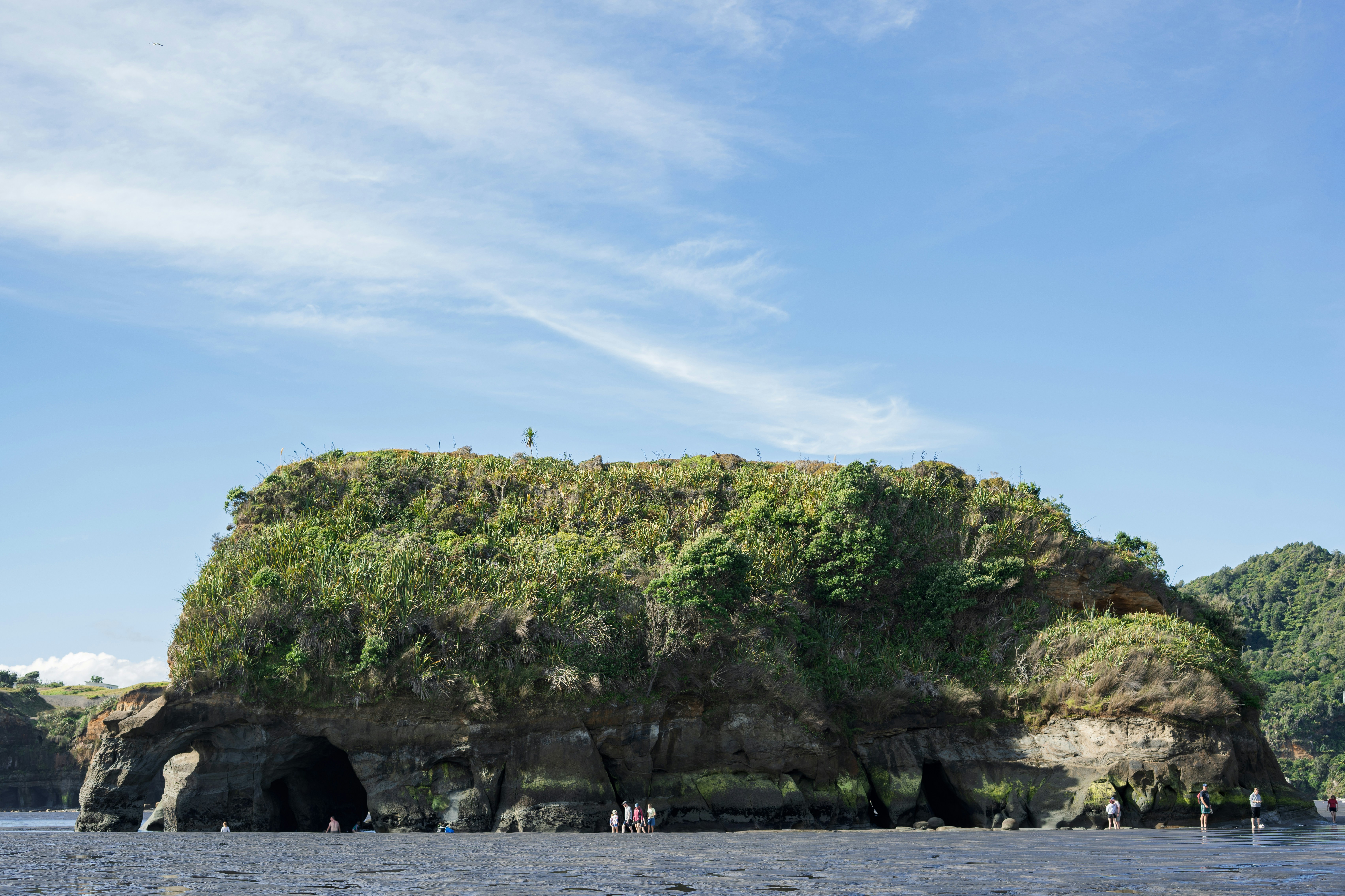 Sunlit Cliff Island Emerging from Calm Coastal Waters