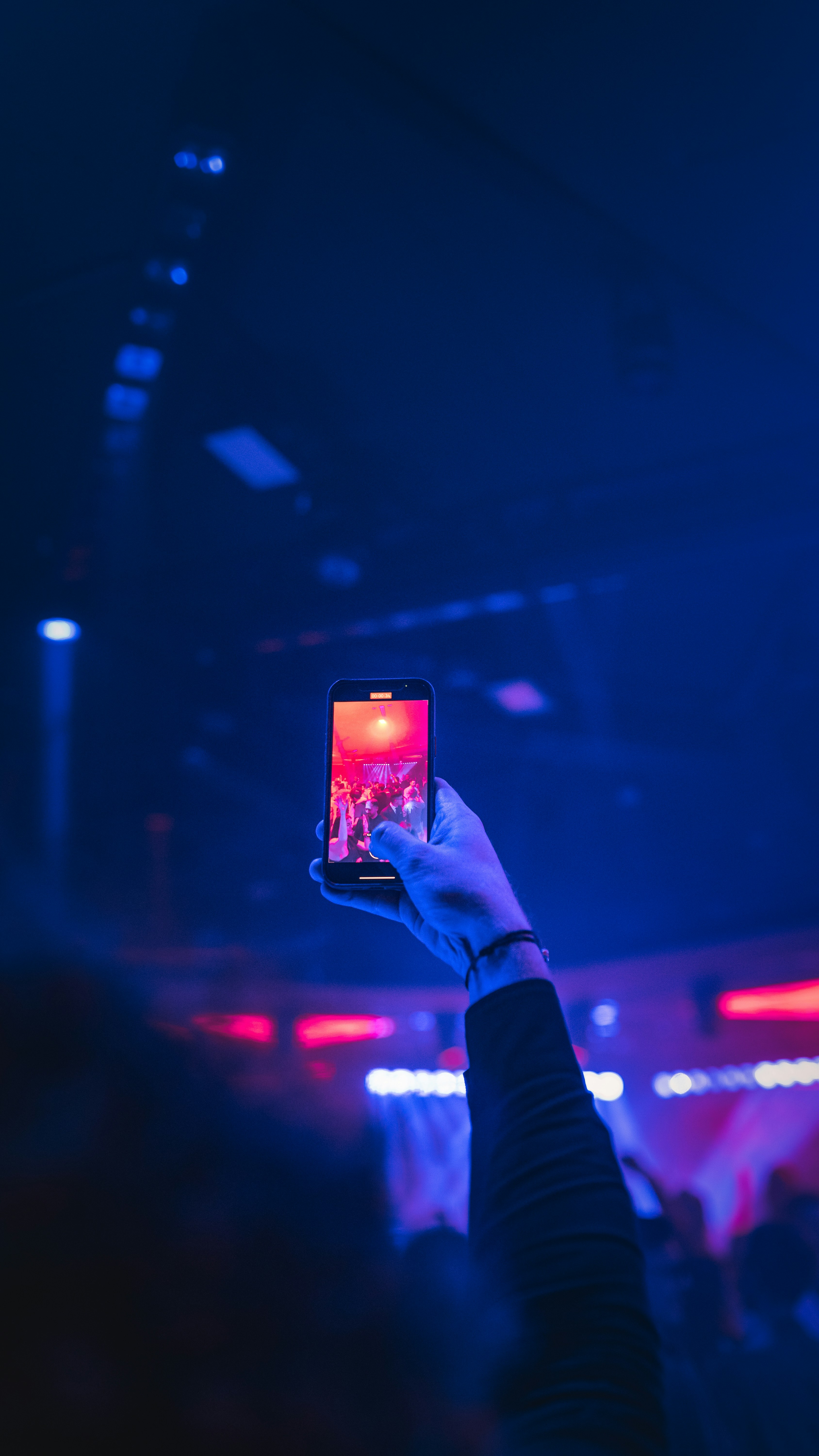 Phone-spotlight: a concert-goer captures the moment
