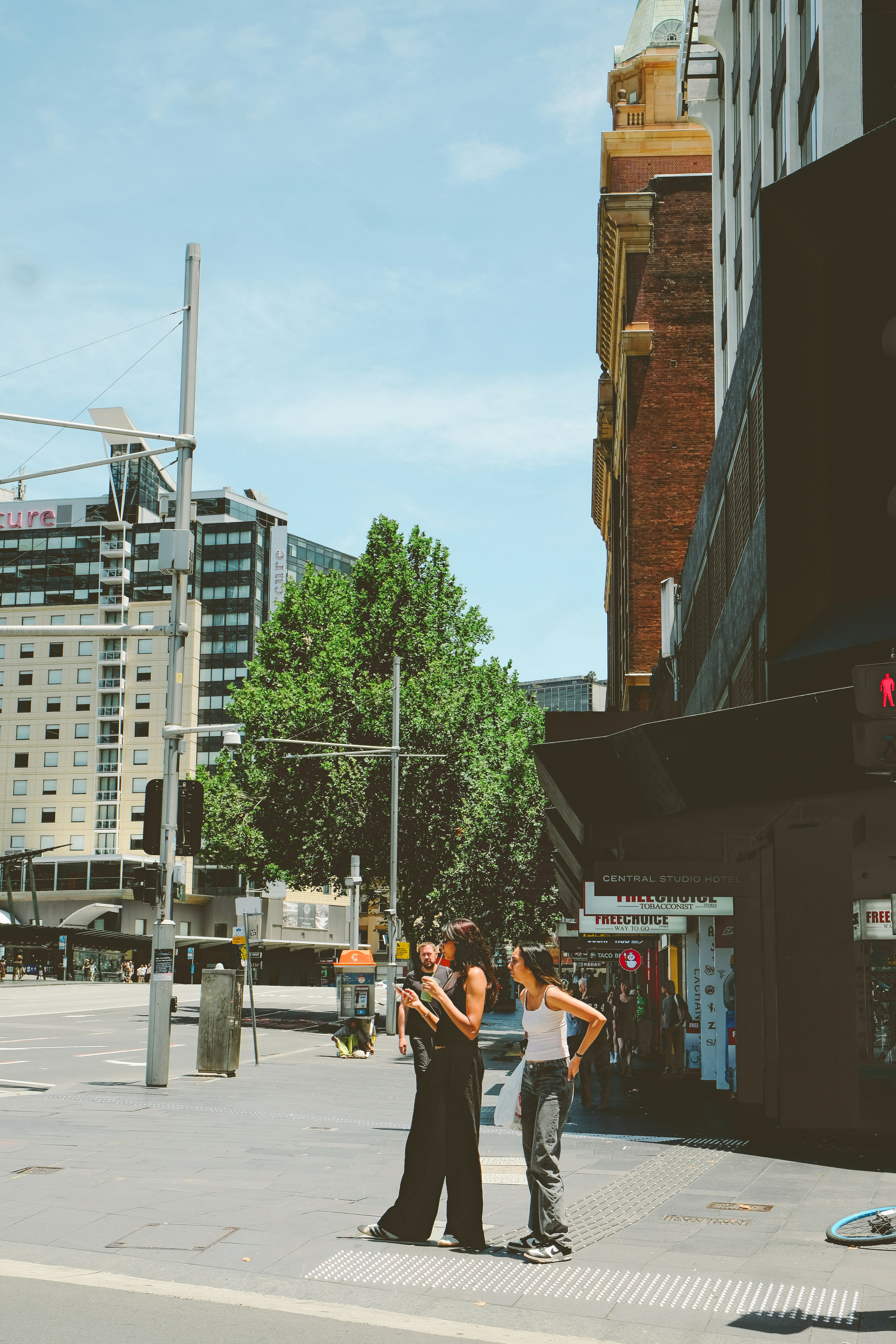 Two women standing on a city street corner.