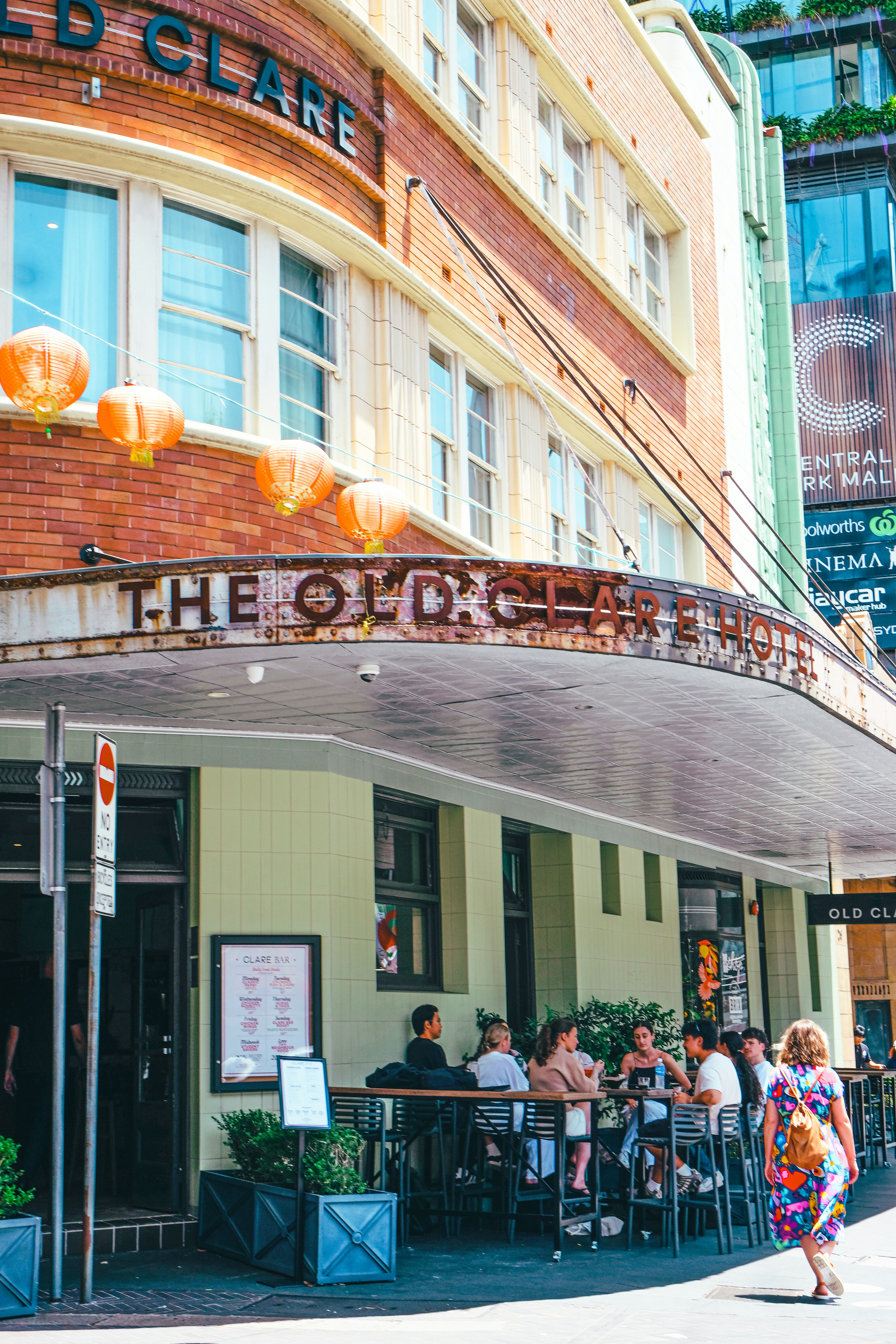 Old Clare Hotel Facade: Neon Strips, Lanterns, and a Lively Street Café