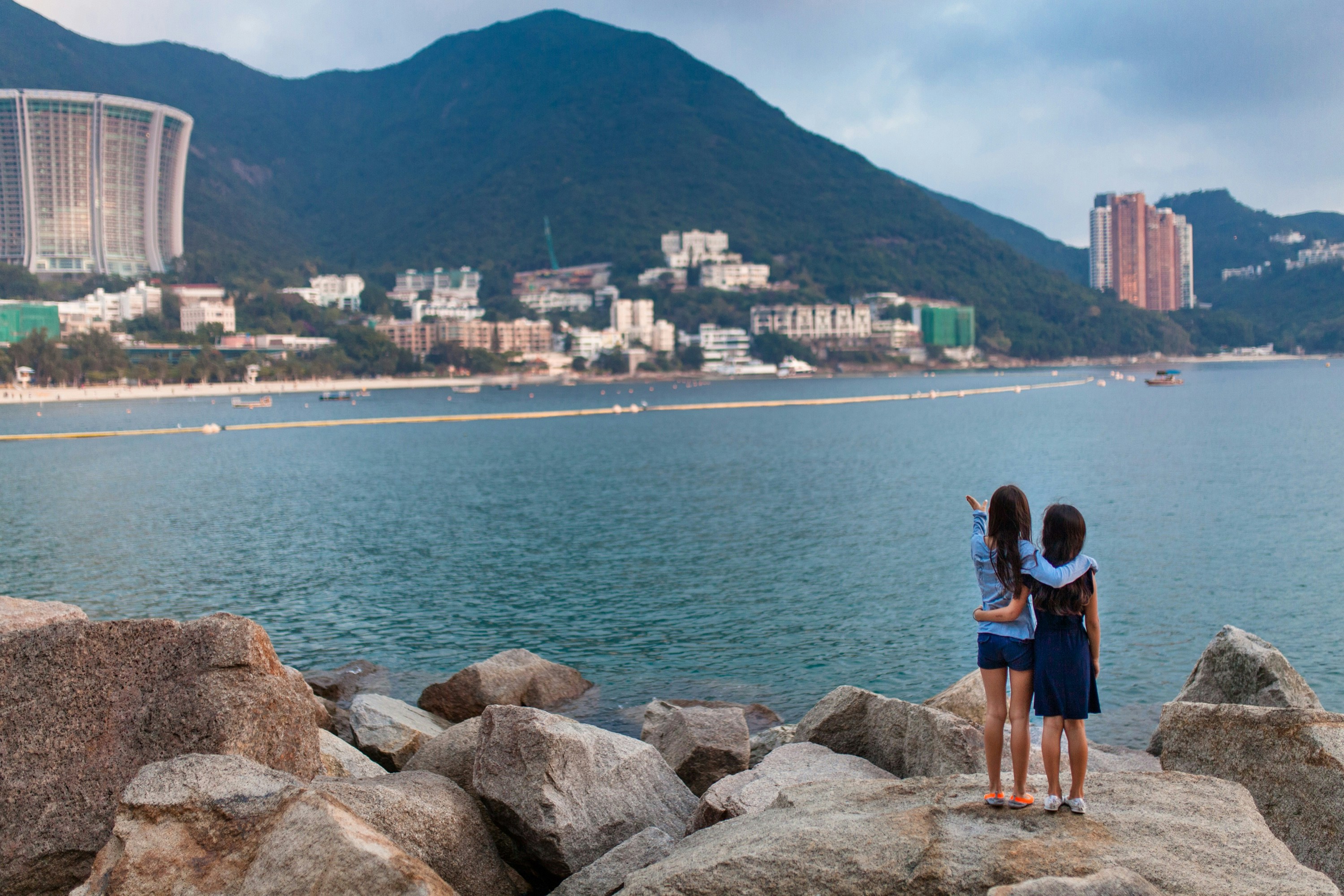 Two Friends at the Edge: Quiet Coastal Promenade Embraced by Urban Hills