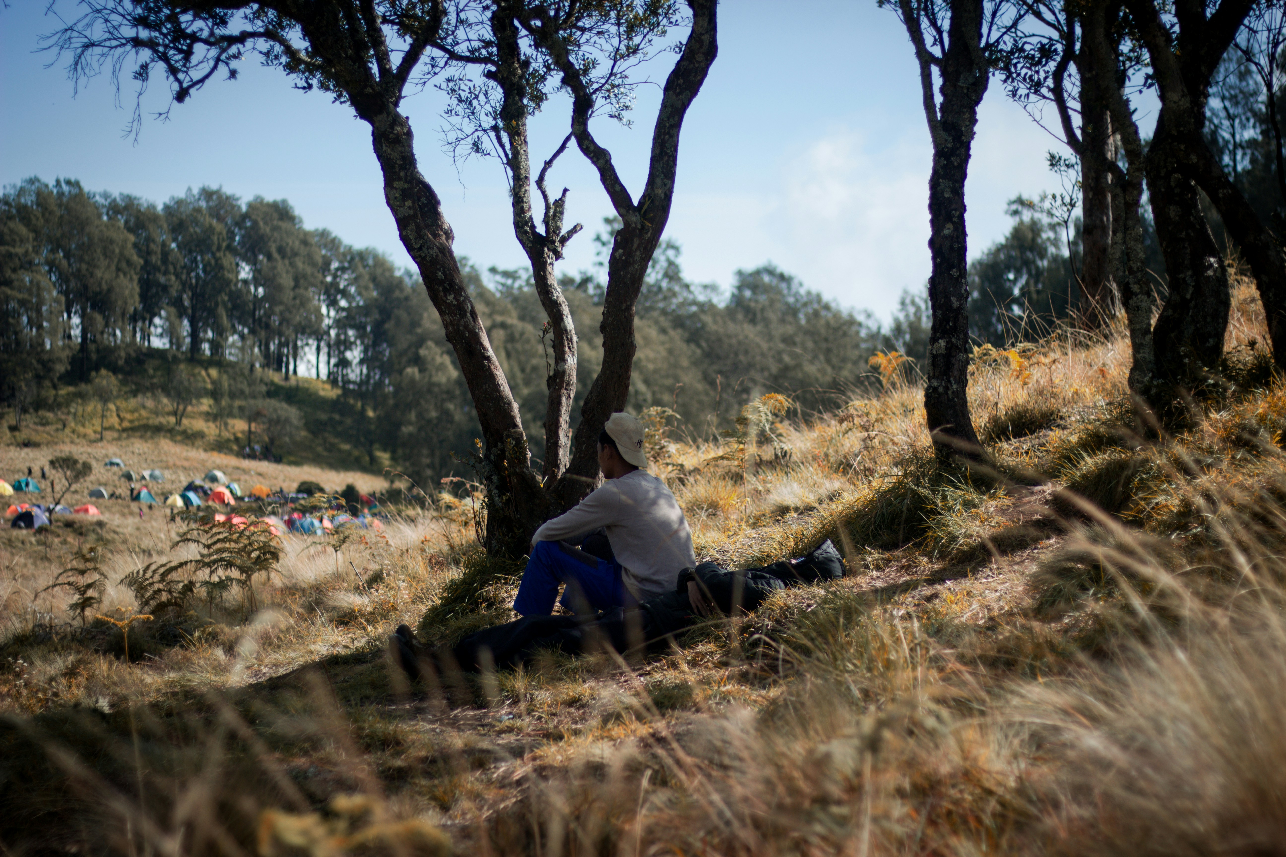 Silhouette of a Hiker Resting in a Sunny Riverside Slope