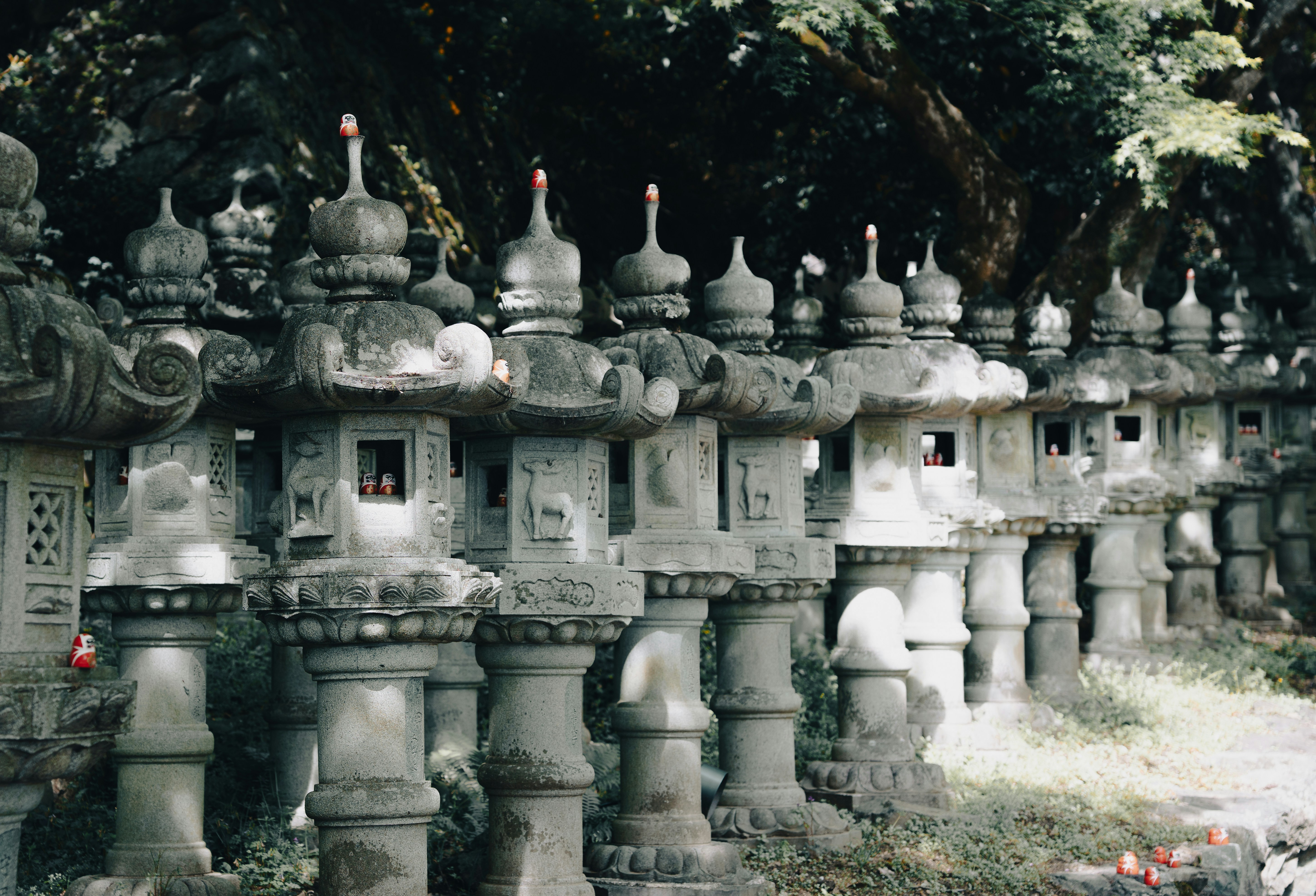 Row of ancient stone lanterns under a shaded canopy