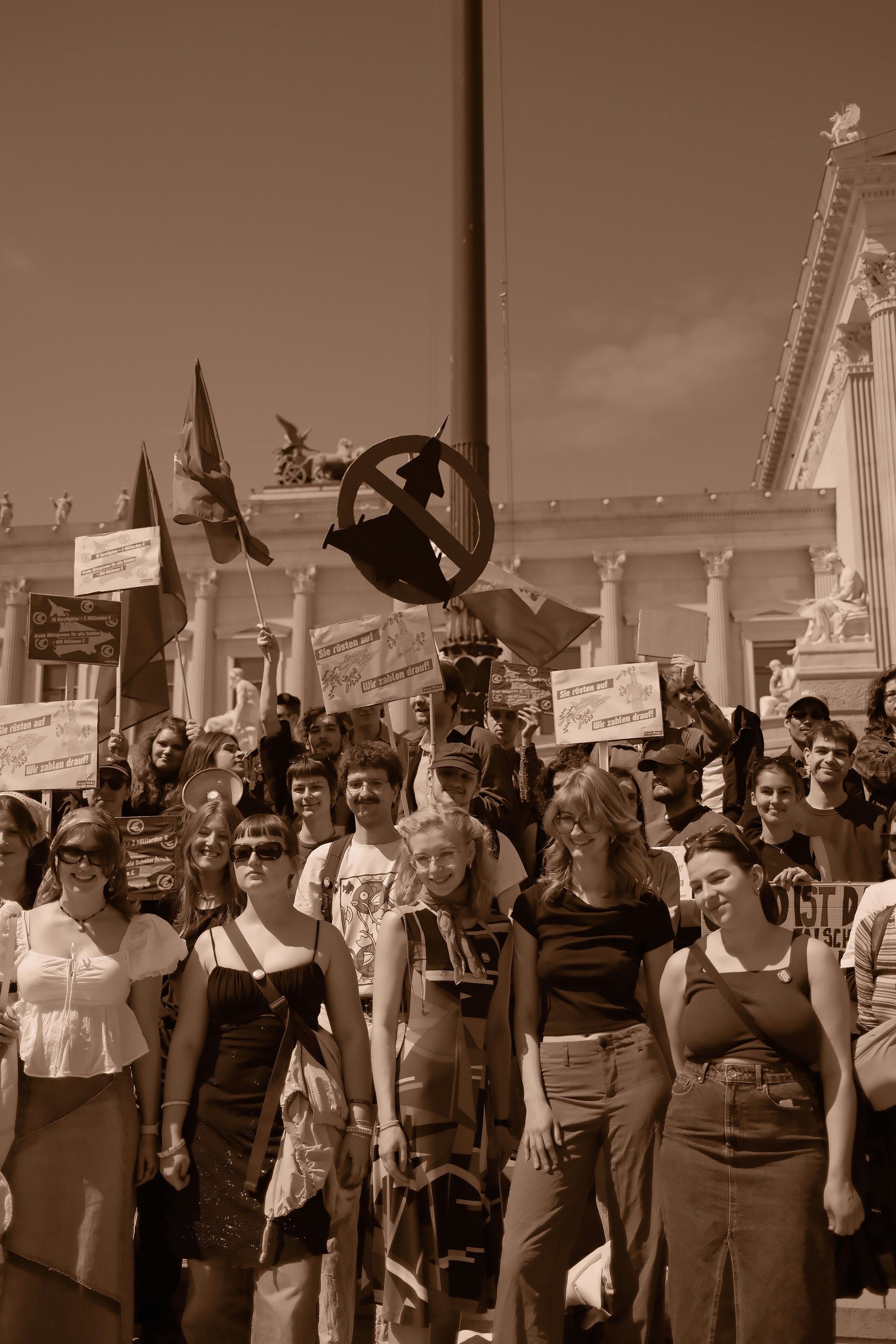 Crowd of protesters under a no-entry sign in front of a grand neoclassical building