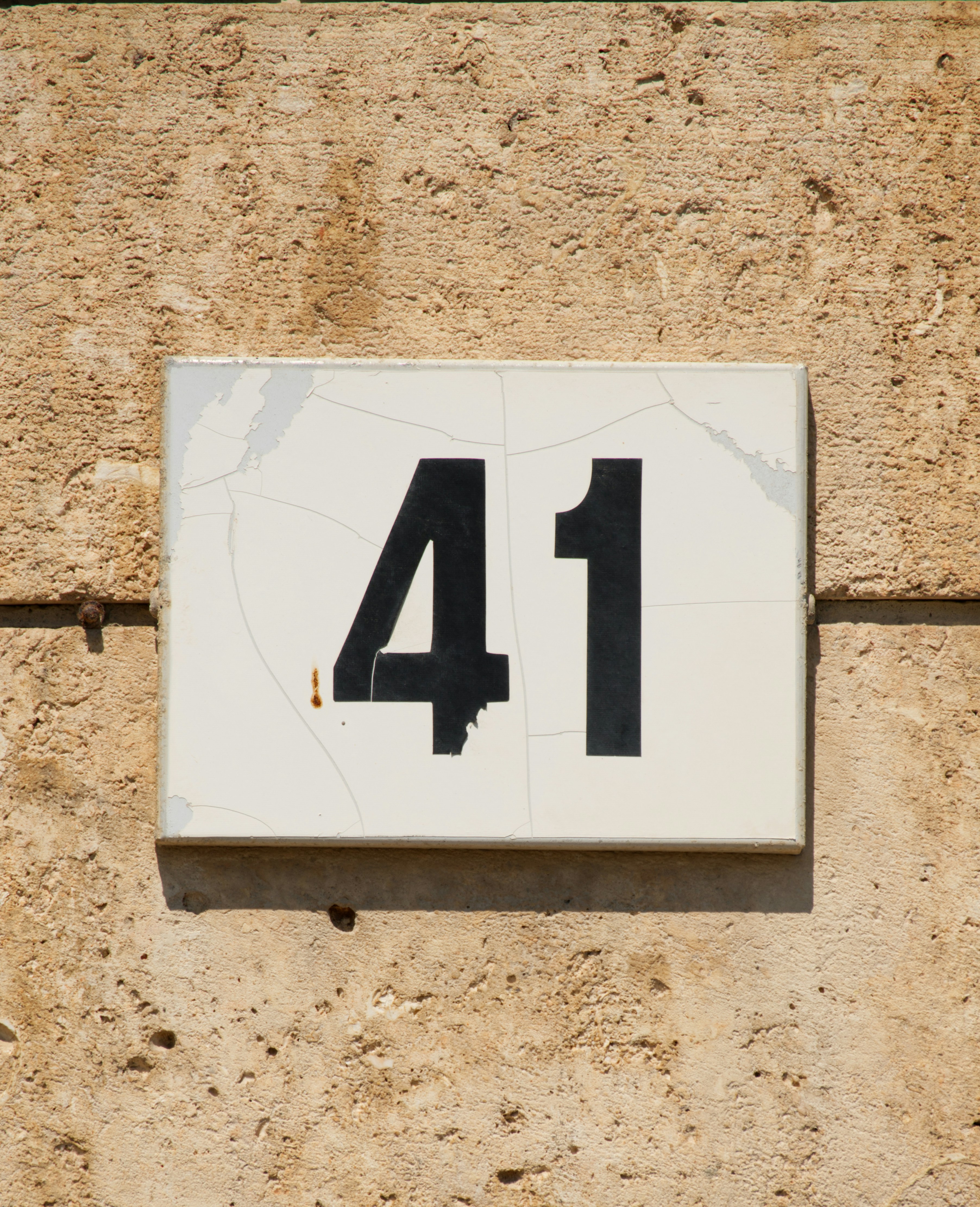 Cracked Tile Sign: Addressed 41 on a Weathered Wall