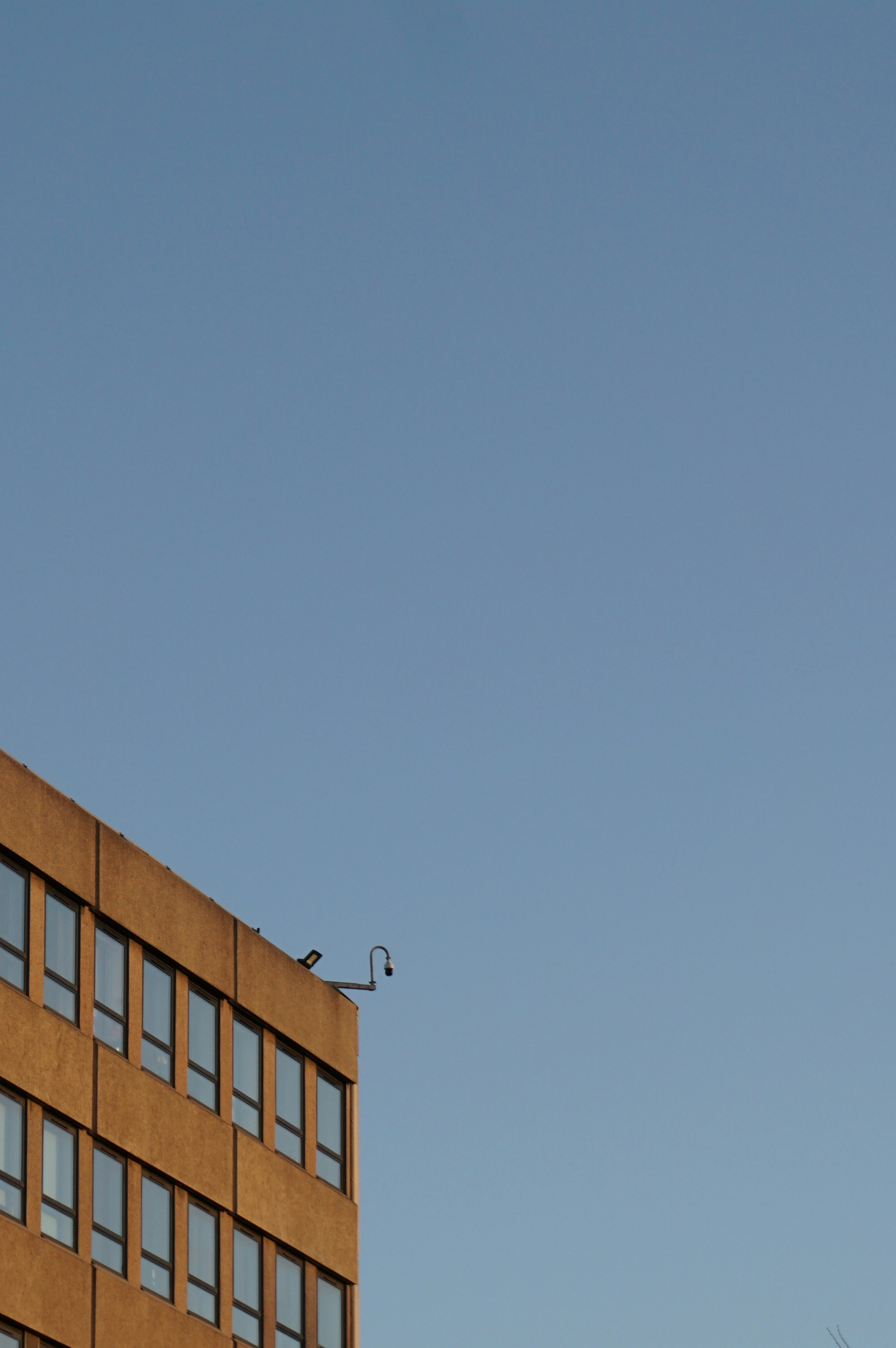 Corner of a tan building against a clear blue sky. photo – Free ...