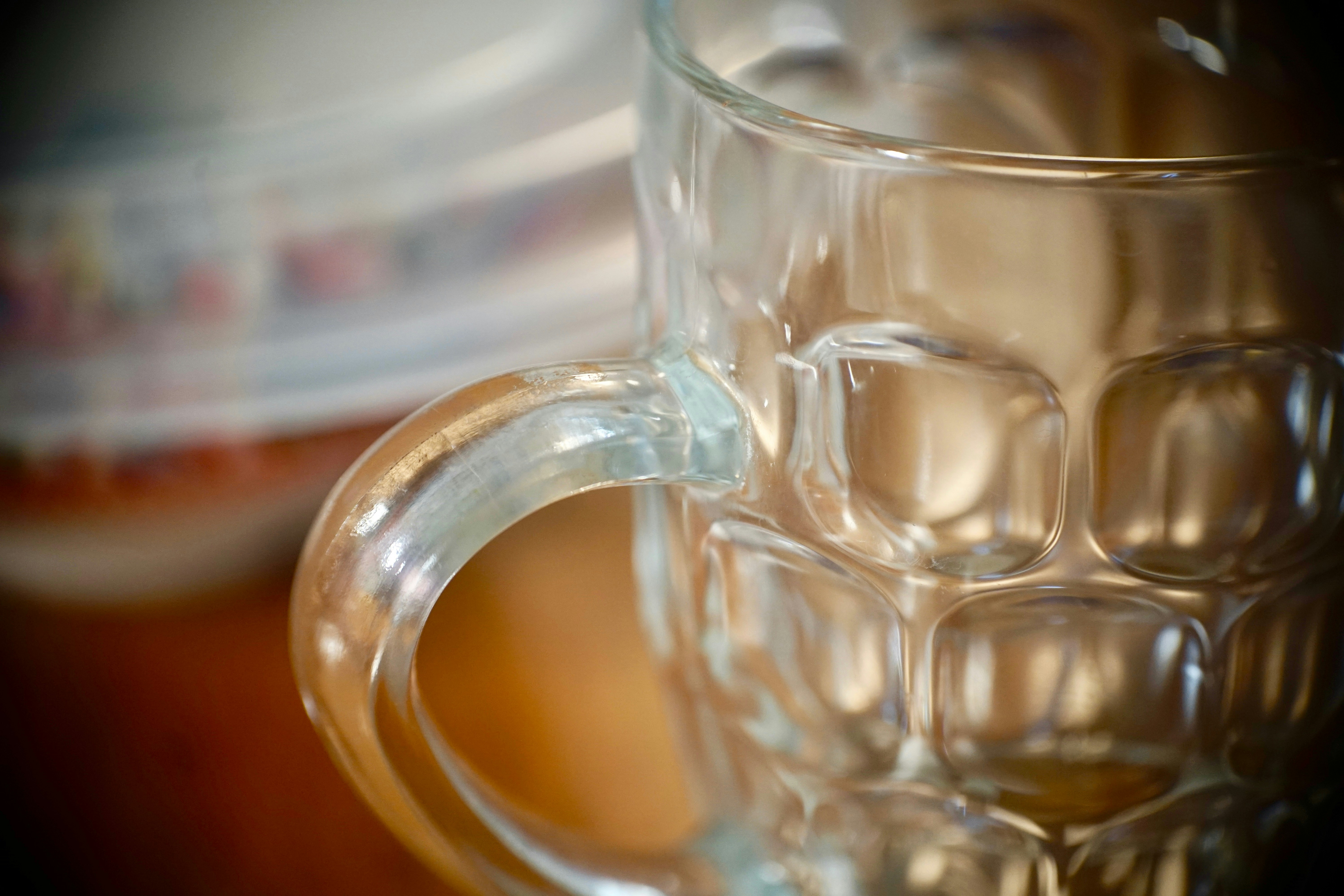 Clear Glass Mug with Interlocking Dimpled Pattern, Blurred Kitchen Background