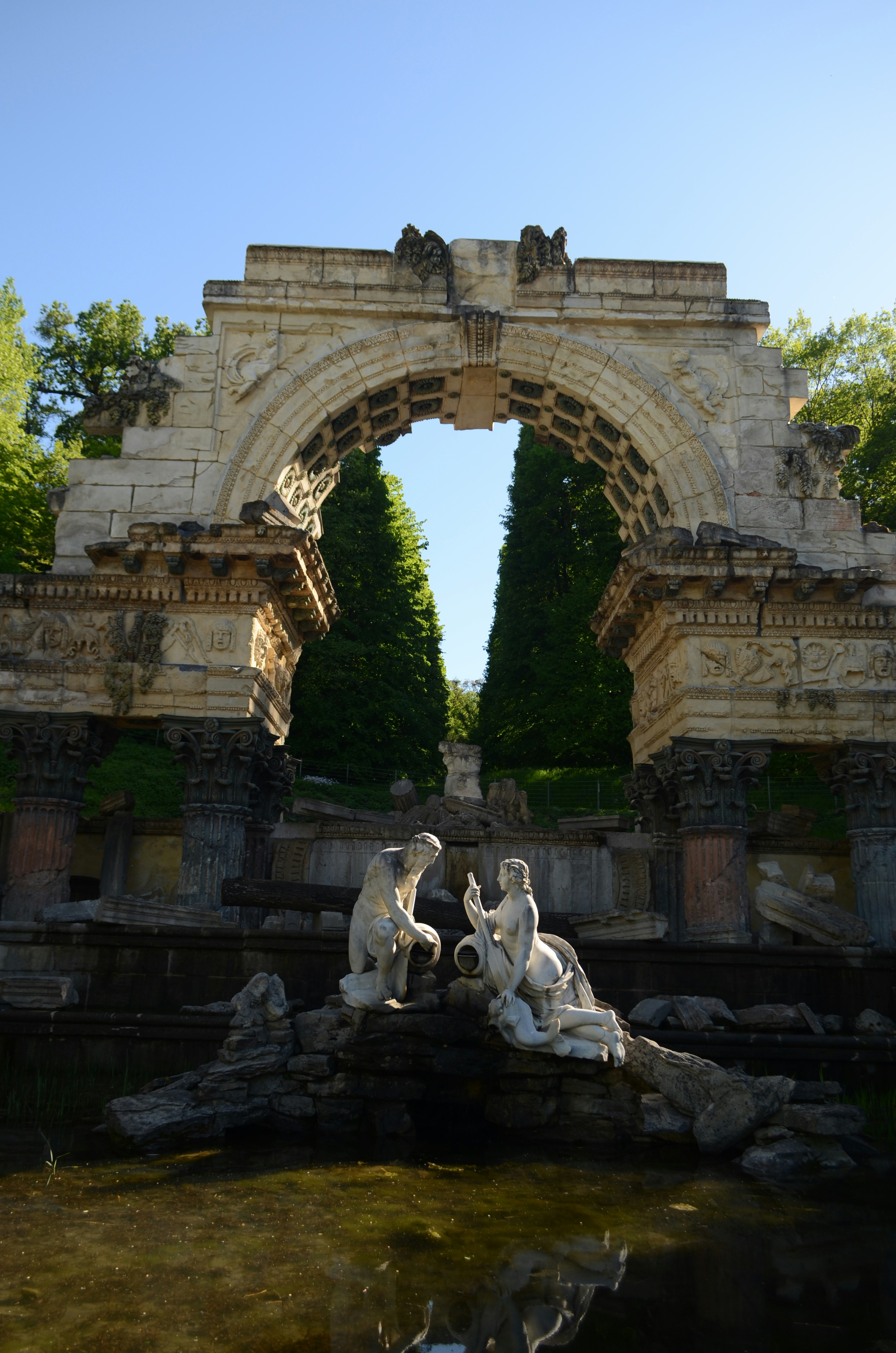 Ancient Arcadia: Granite Arch Framed by Water and Statues