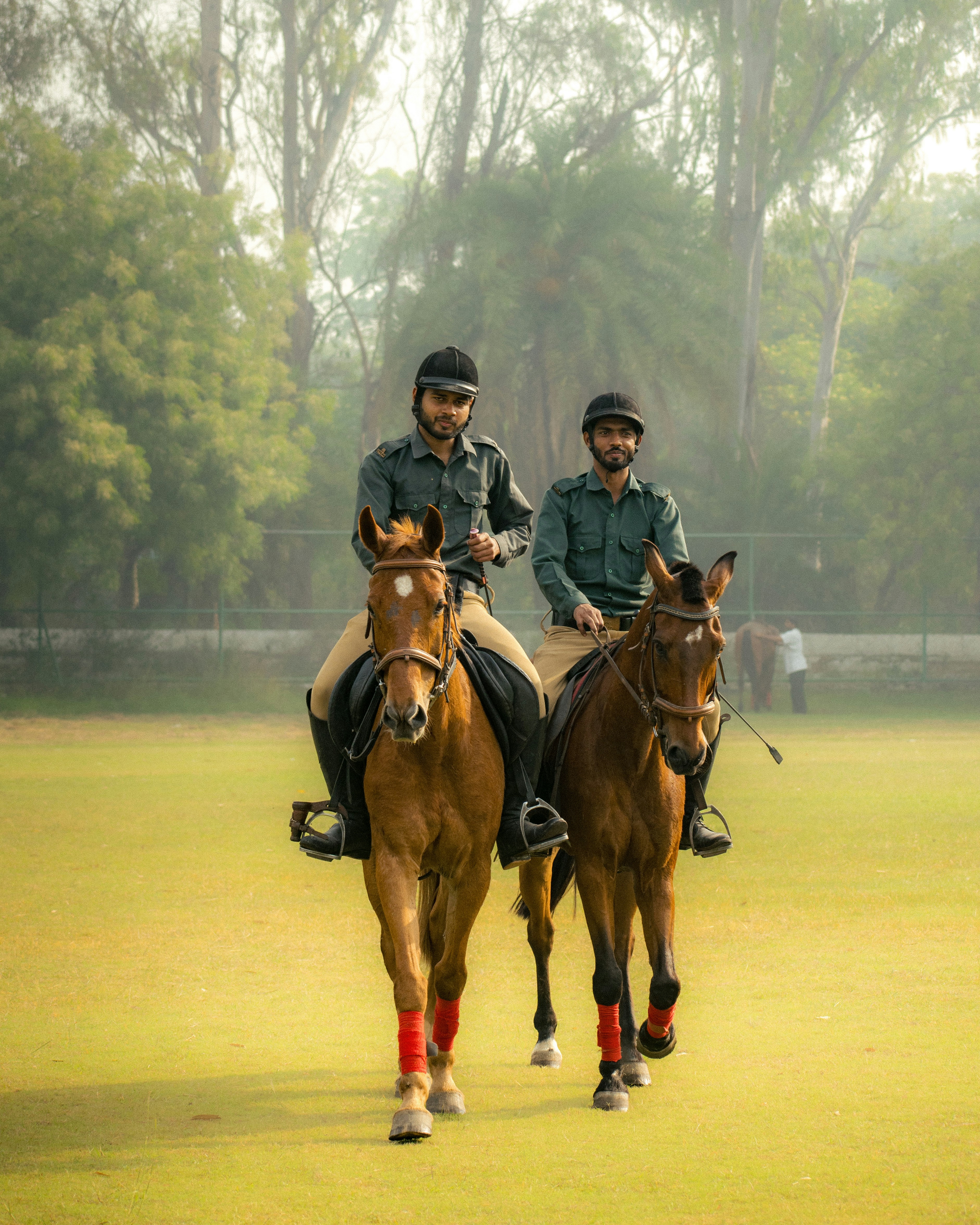 Two Riders in Matching Green Kilts Ride Side-by-Side on Chestnut Horses