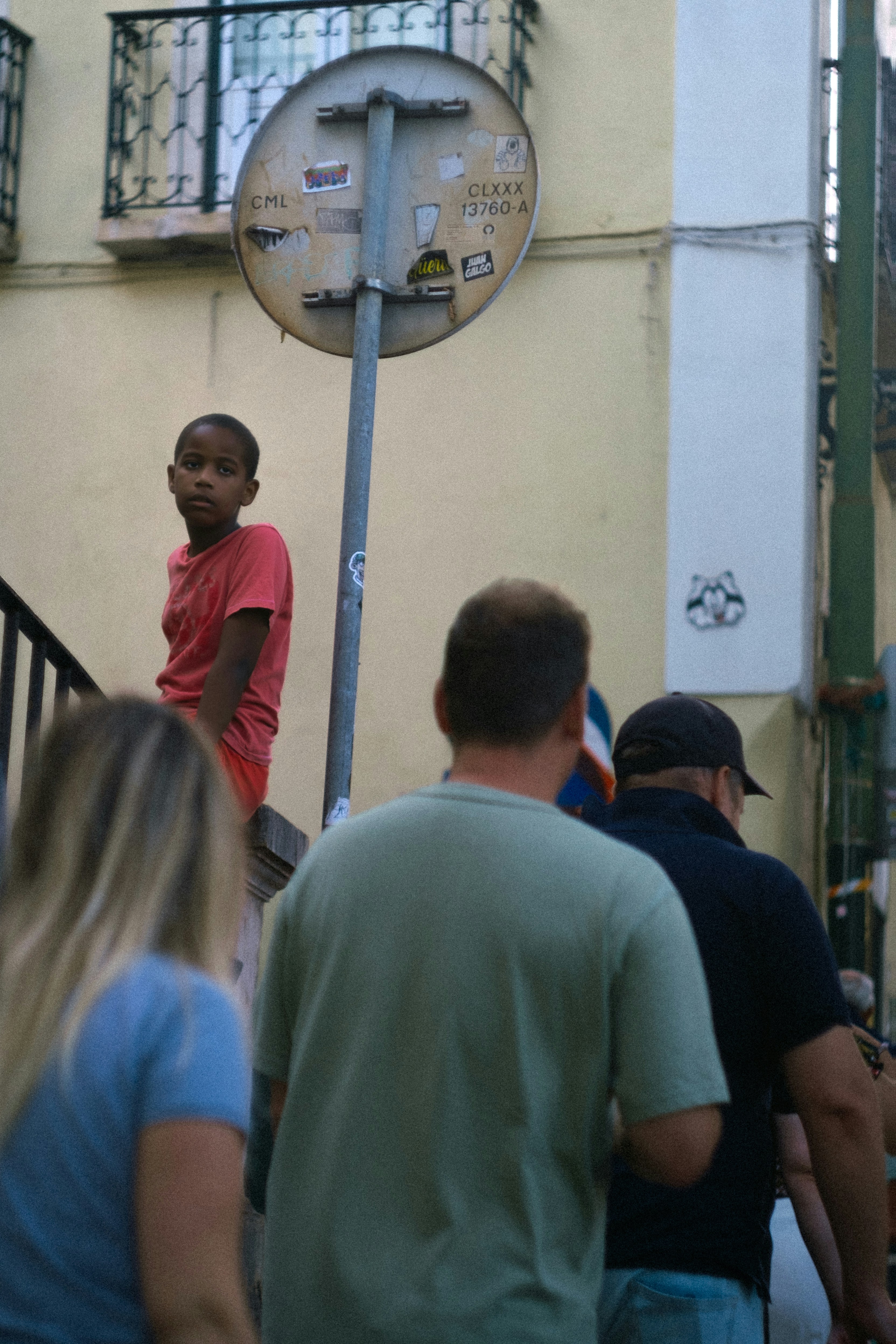 Youth Exit: A Lone Red Shirt Amid a Street Portrait