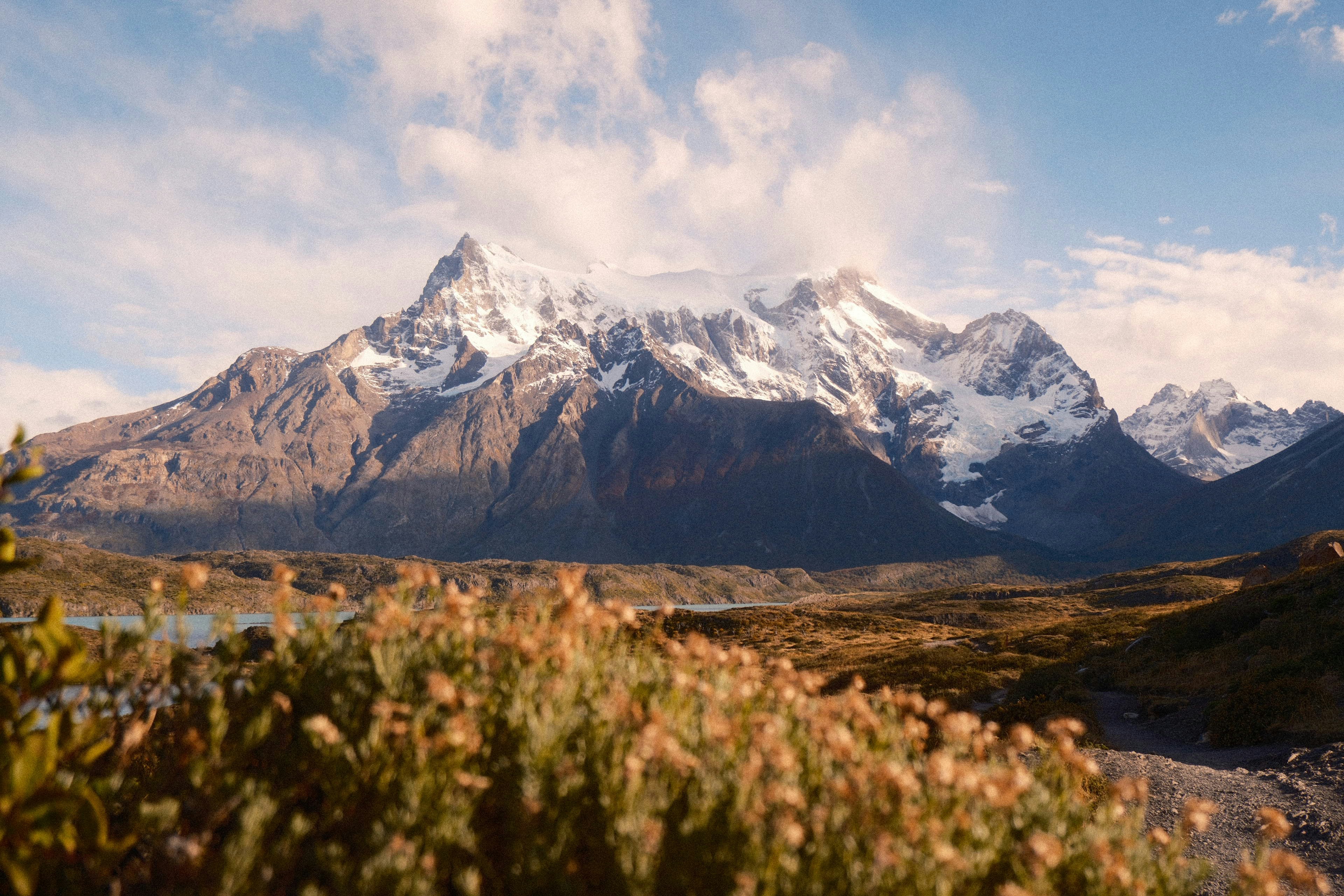 Snow-Capped Peaks Rise Over a Golden Foothill Landscape