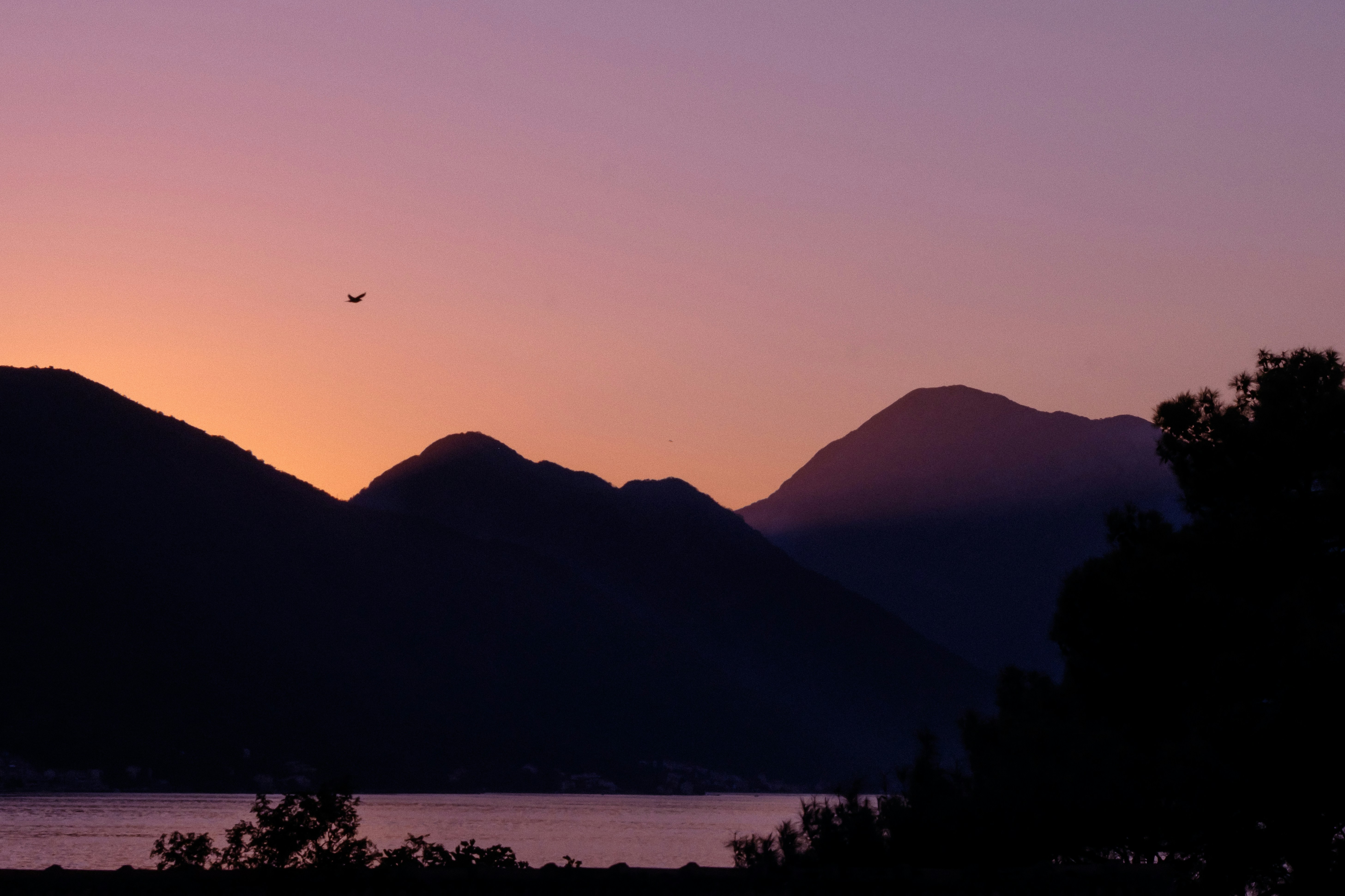 Silhouetted Peaks at Sunset over Quiet Waters