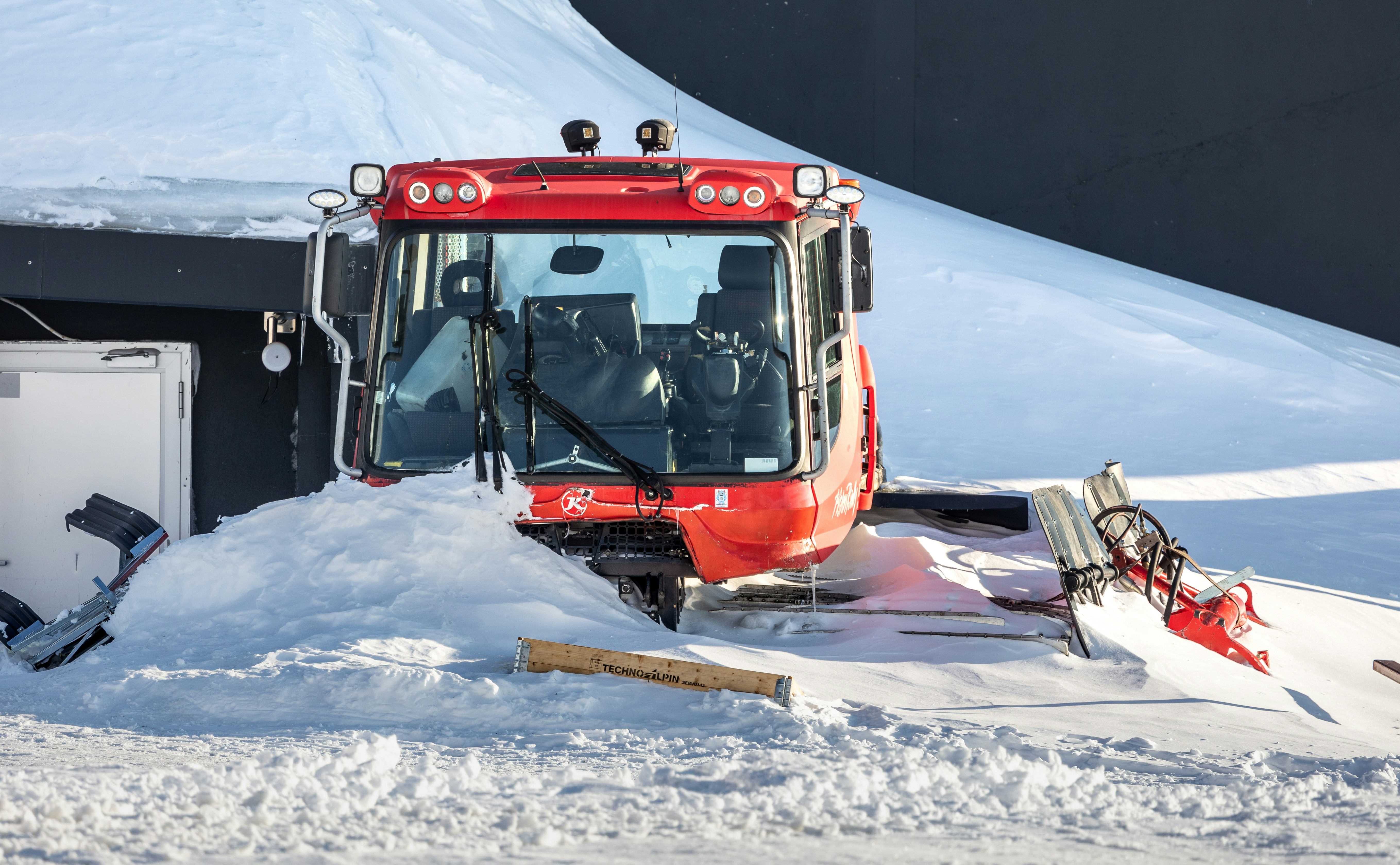 Red Snowplow Emerges from an Alpine Tunnel