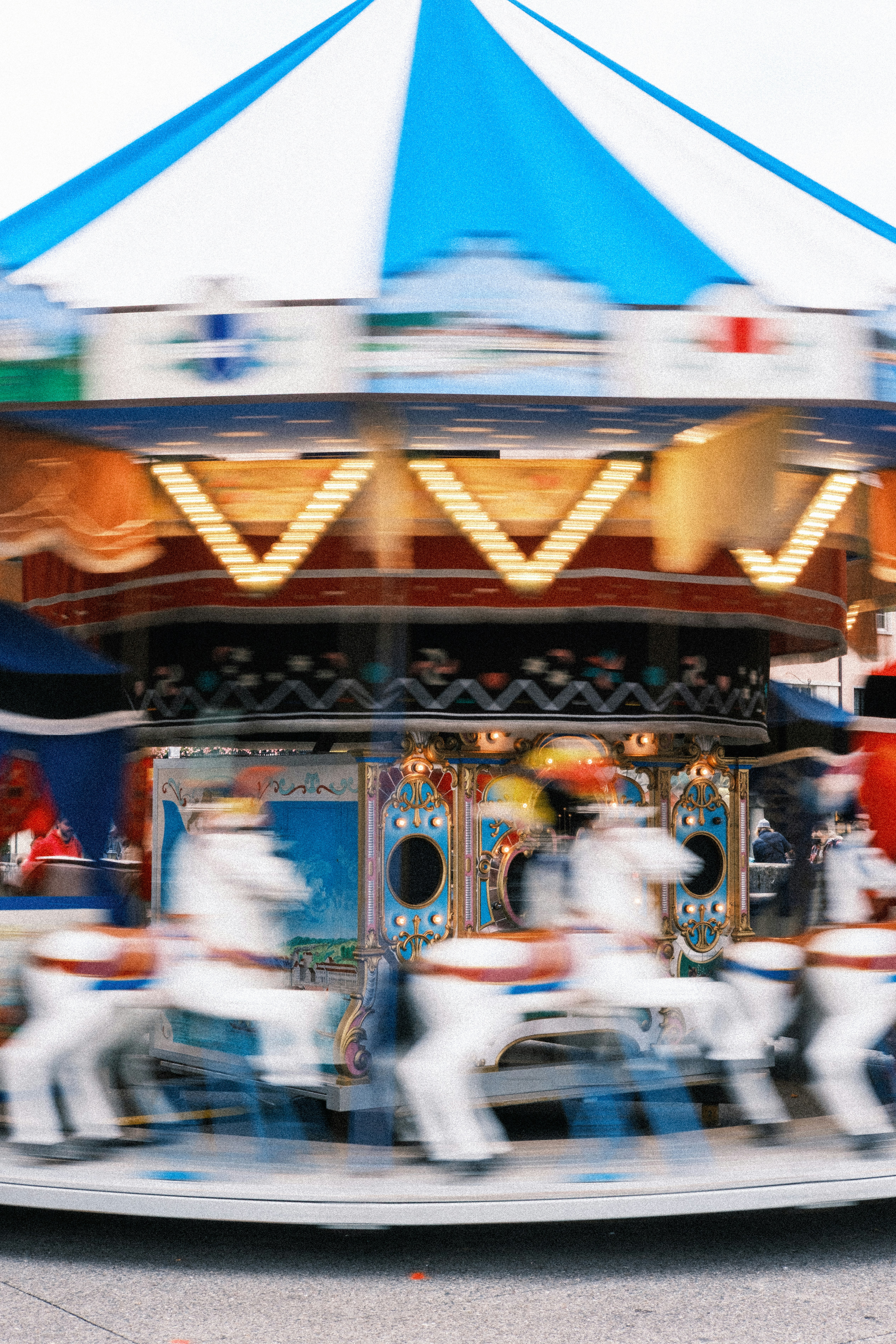 Whirling Carousel in Motion: Blurred Riders under Neon Cheer
