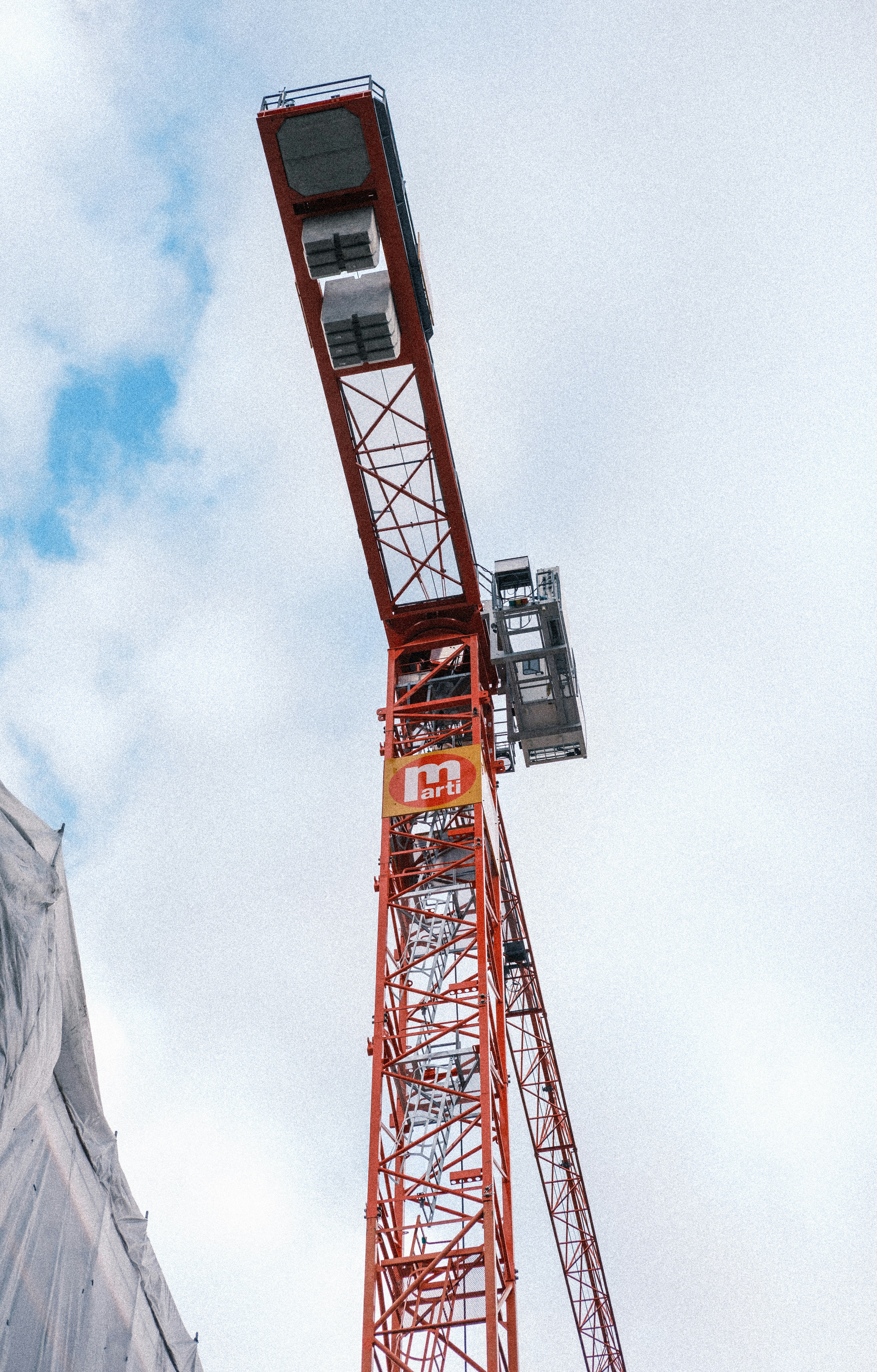Crane Crest: A Red Tower Reaches Skyward Over City Facades