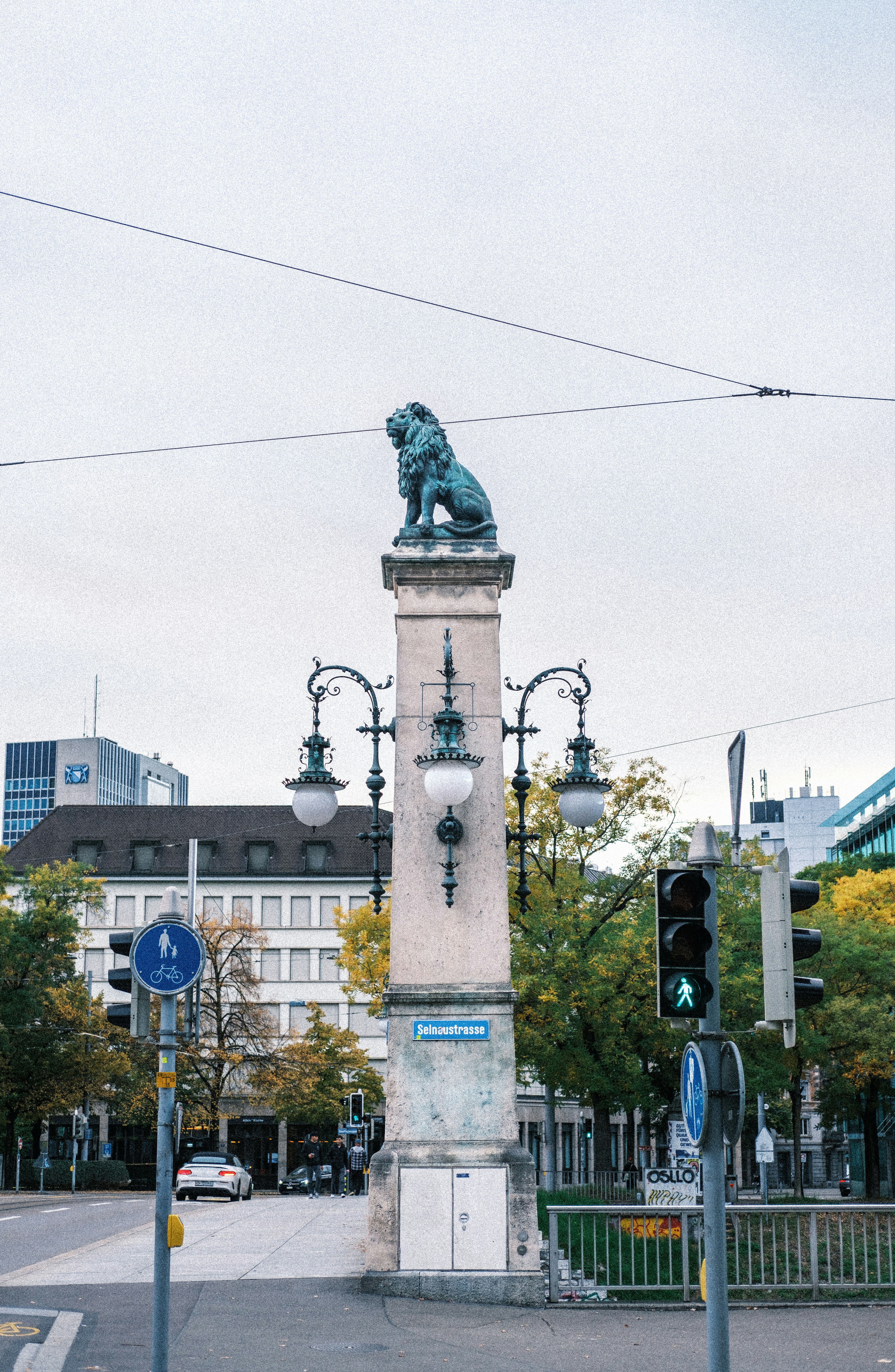 Guardian on the Axis: A City Lion Overlooked by Tram Wires