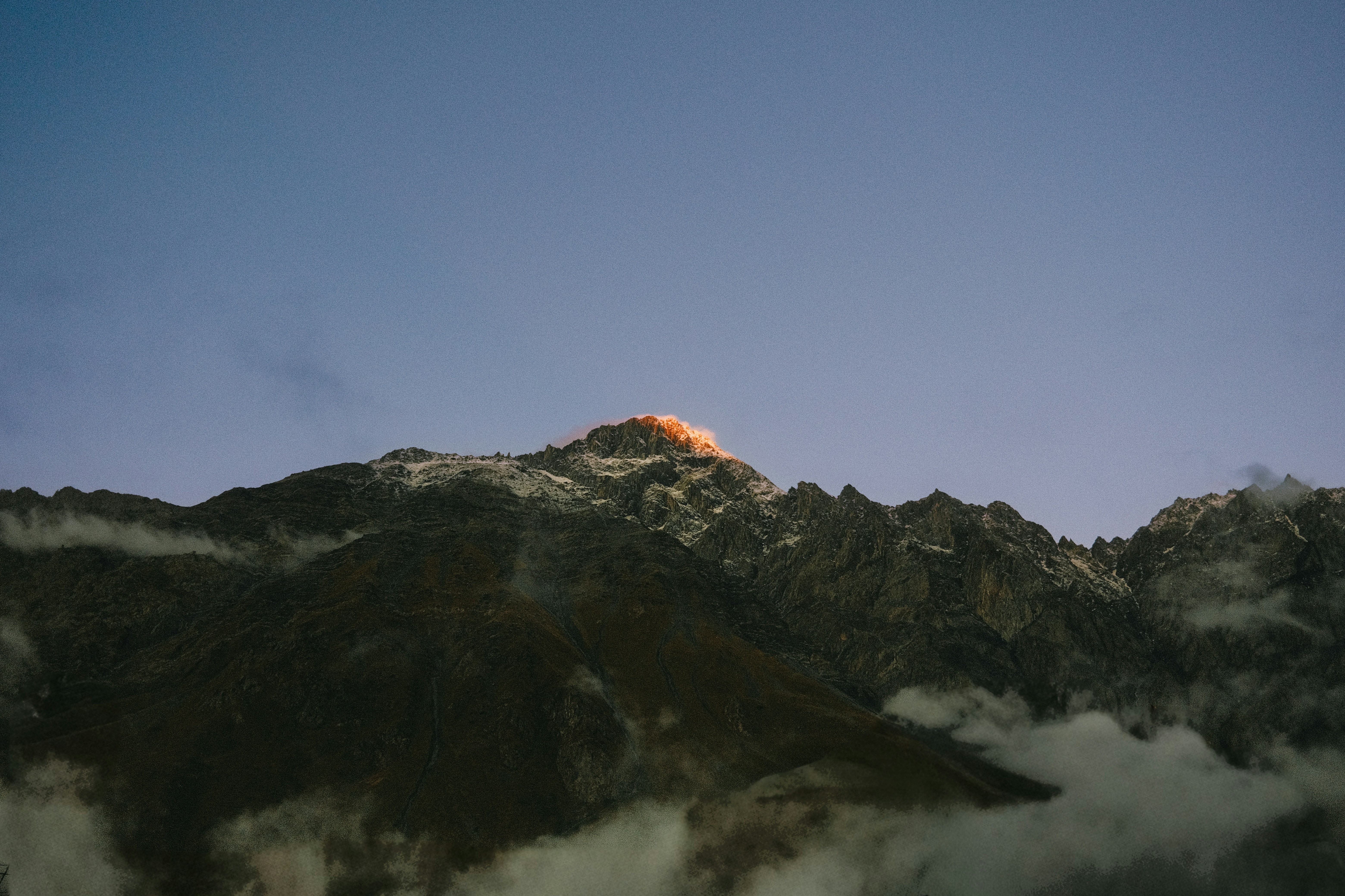 Sunlit Summit: A Glowing Crest Above the Mist