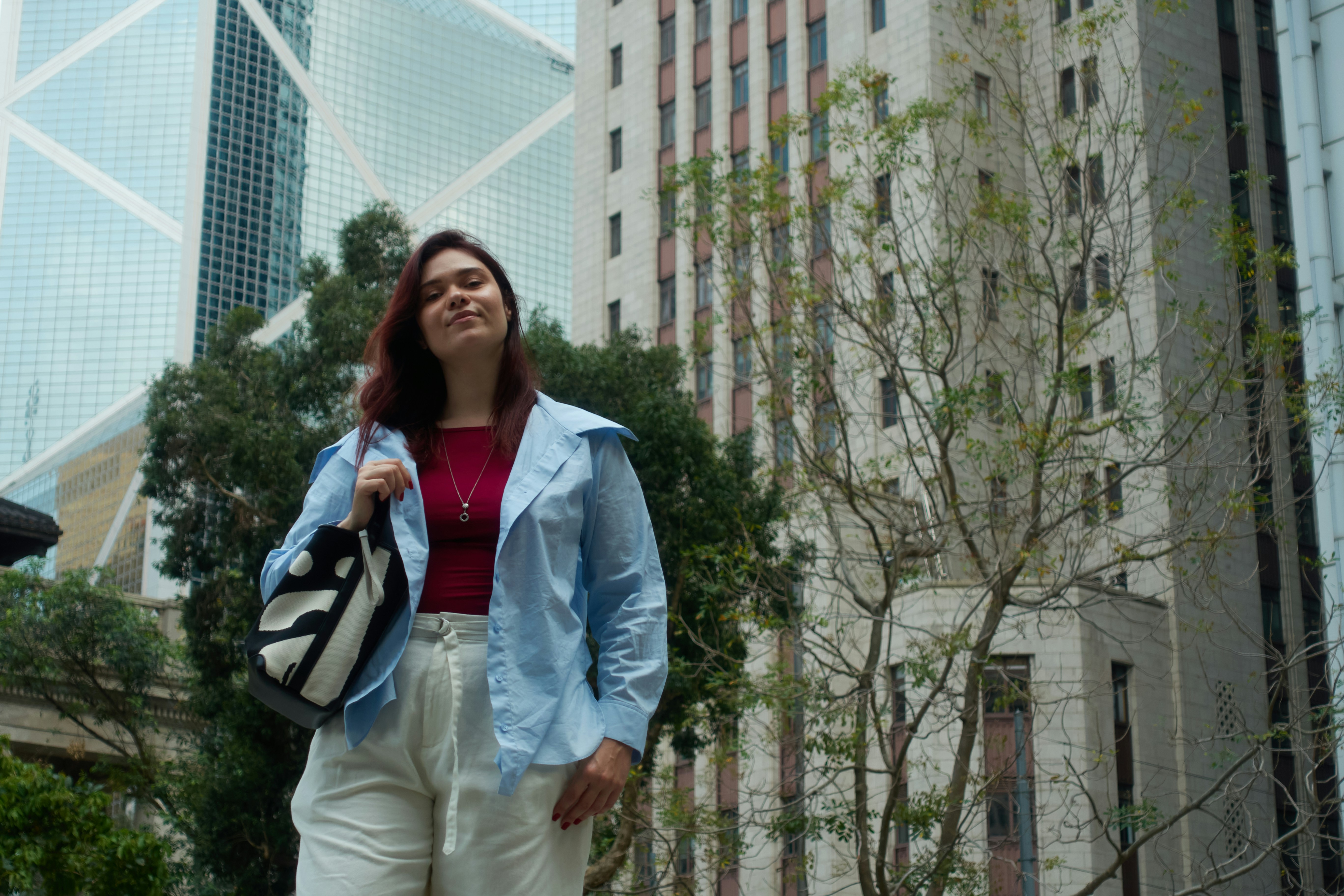 Urban Confidence: A Woman Walks Forward Under High-Rrise Canvases