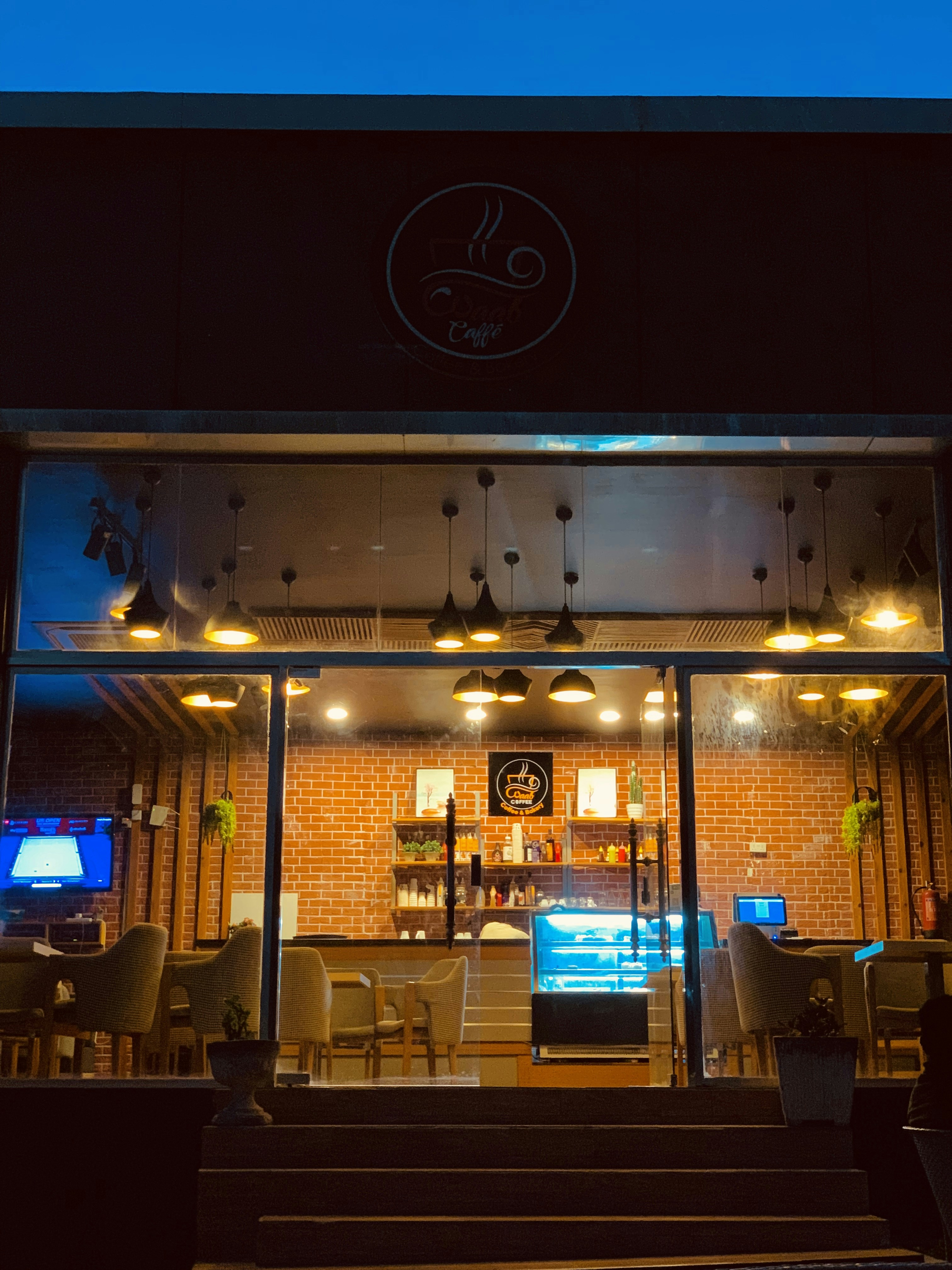 Nighttime Café Glow: Brick Interior Through Glass