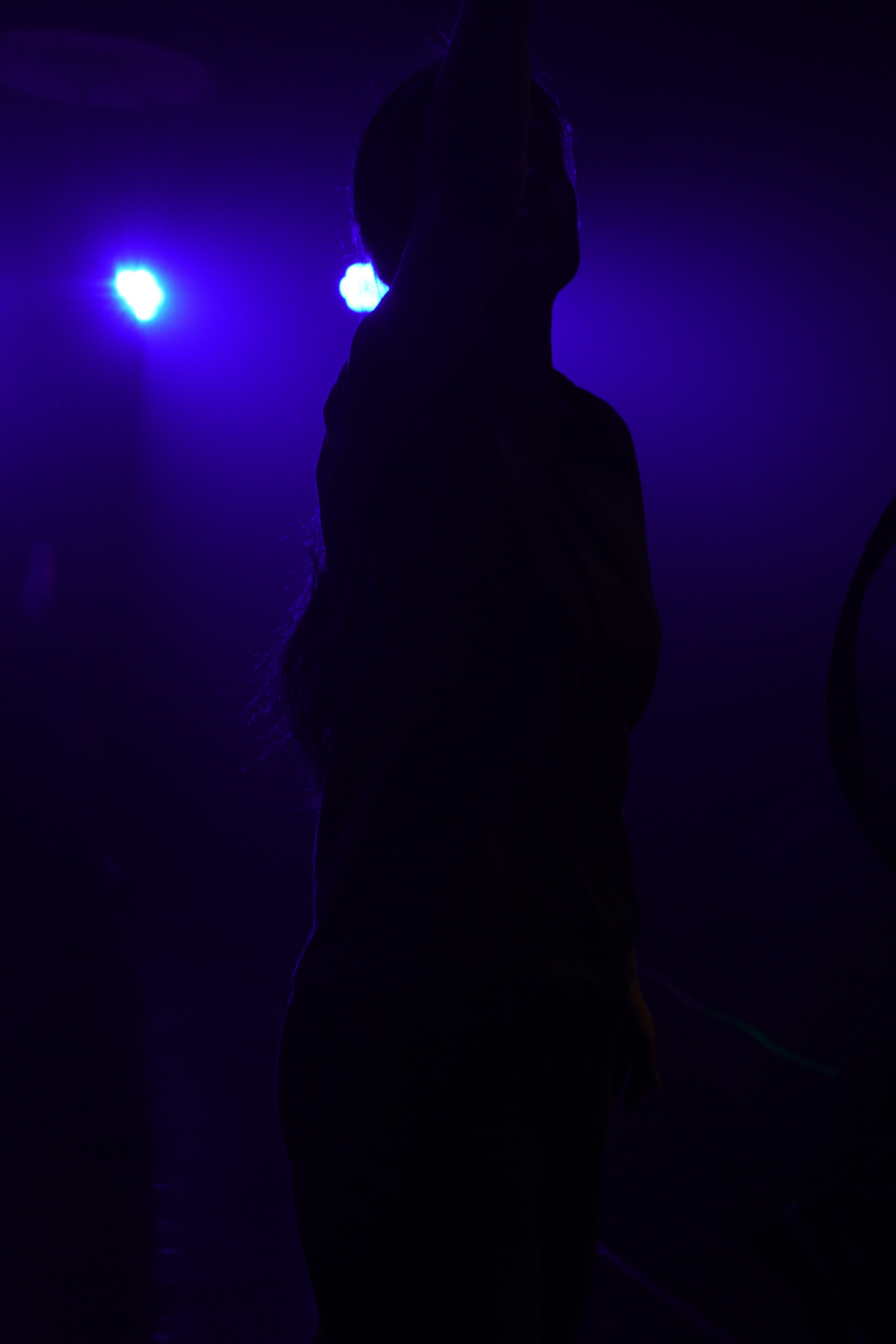 Silhouette on Stage: A Velvet Night with Blue Lights
