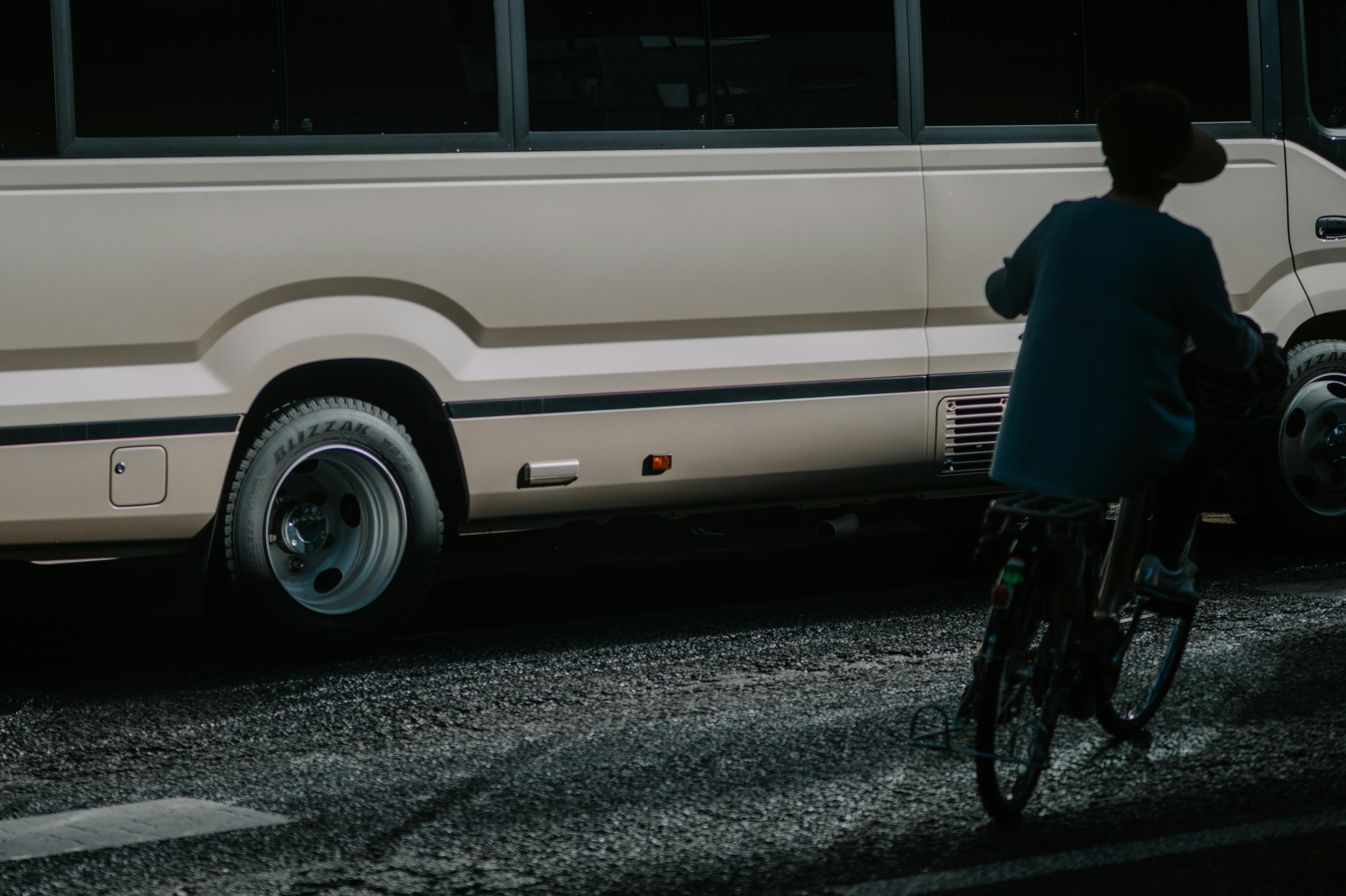 Cyclist in motion beside a vintage bus at dusk