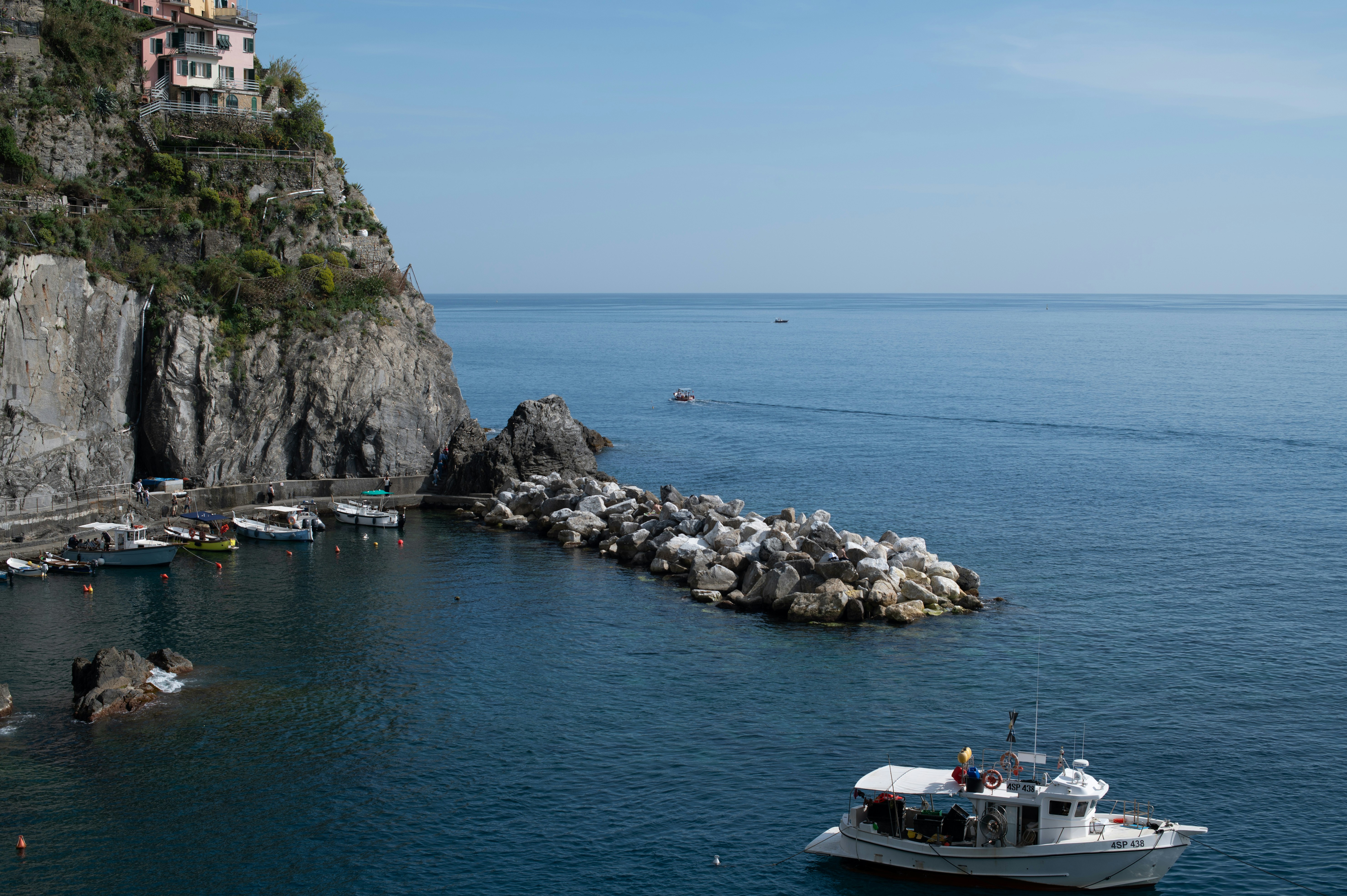 Coastal Cliffs and a Quiet Harbor: A Boat at Dusk