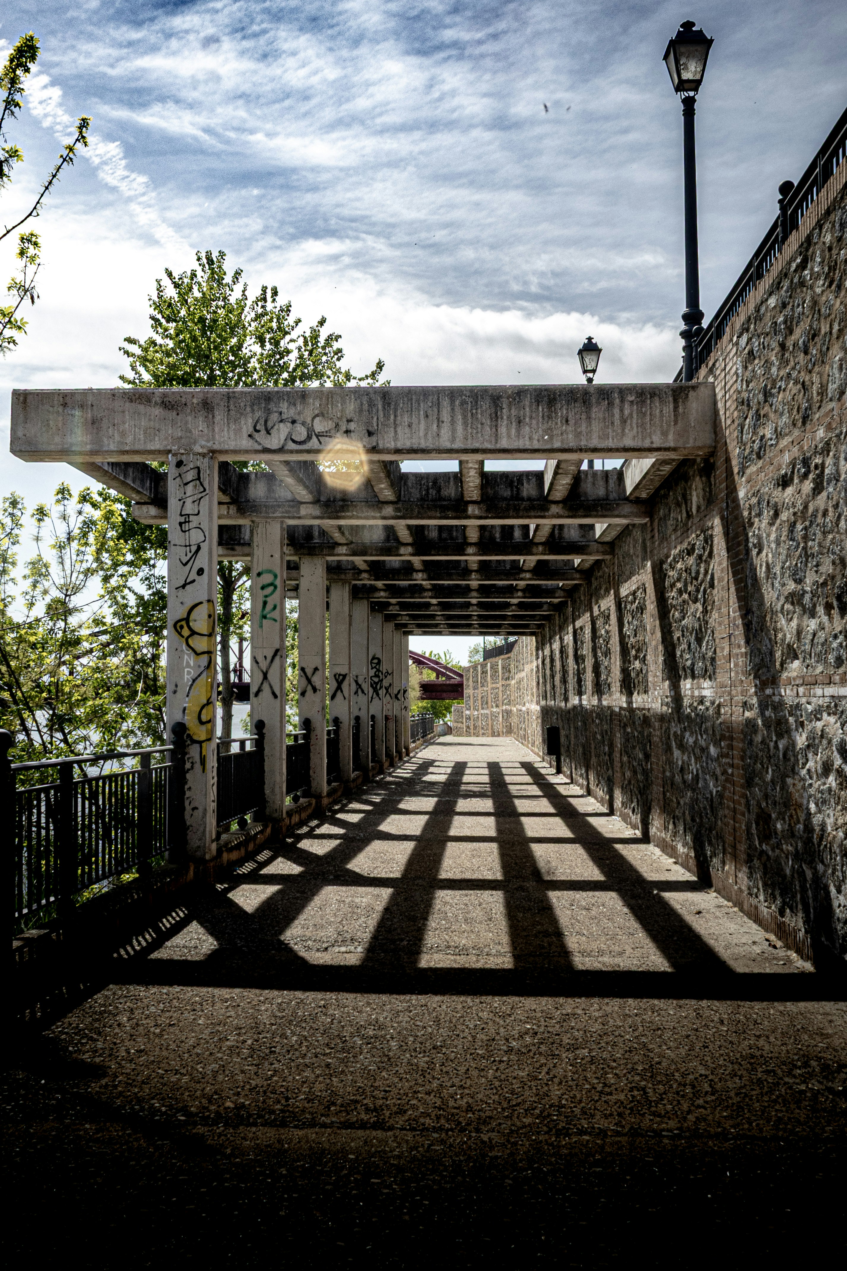 Shadowed Arcade: Sunlit Corridor of Concrete Beams