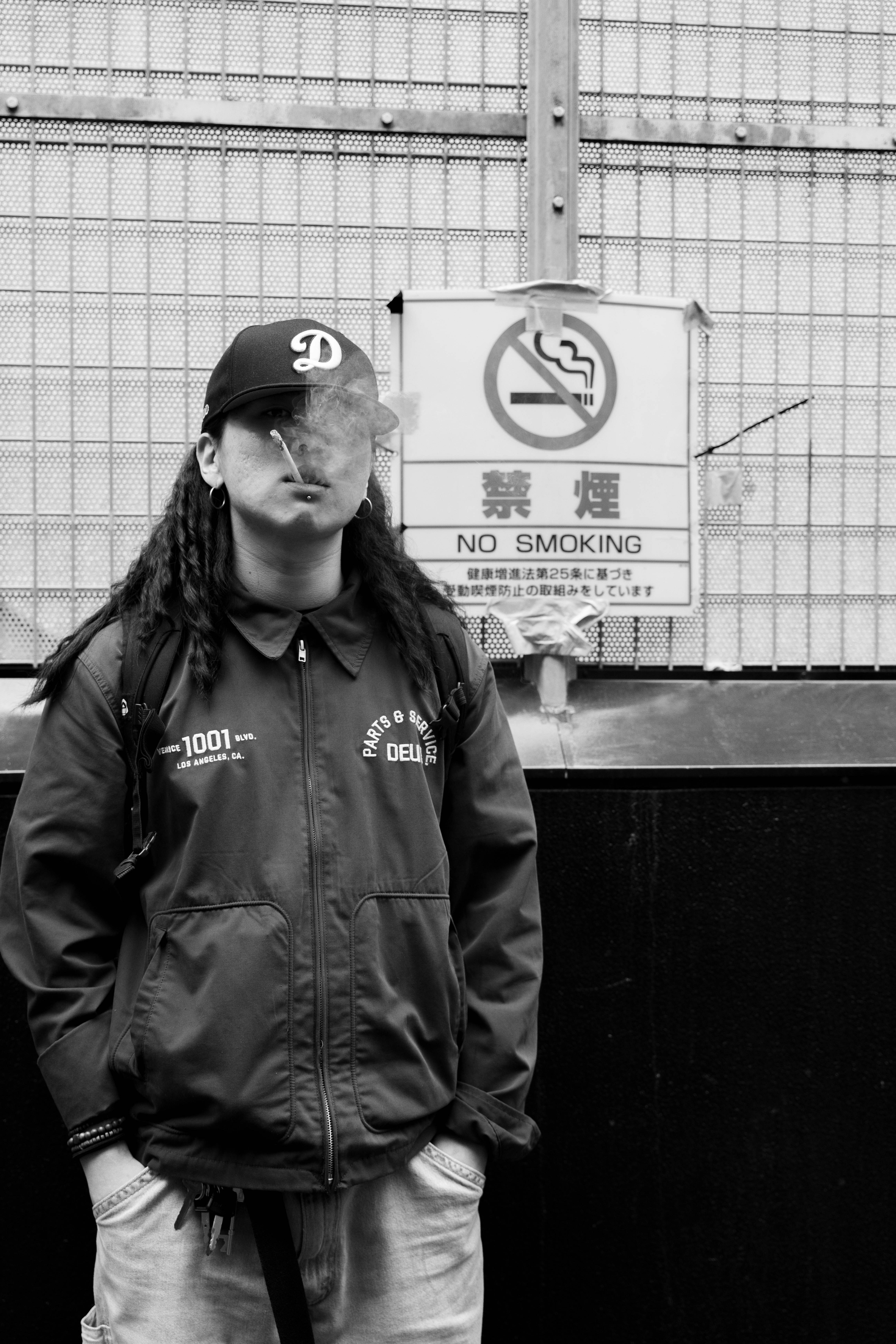 Smoked Silence: A Street Portrait Beneath a No Smoking Sign