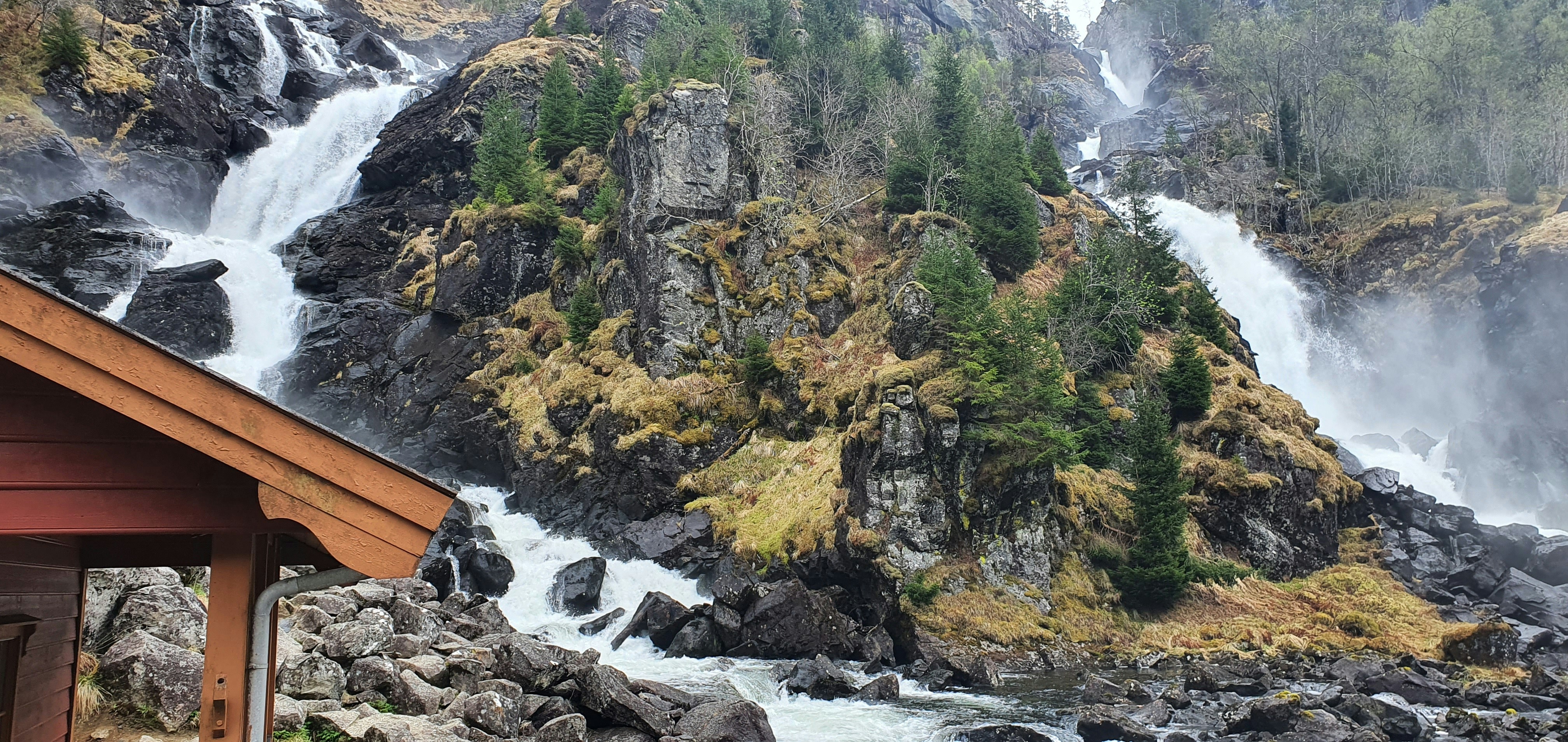 Cascade Overlook: Timber Roof and Rapids Against a Rugged Cliff