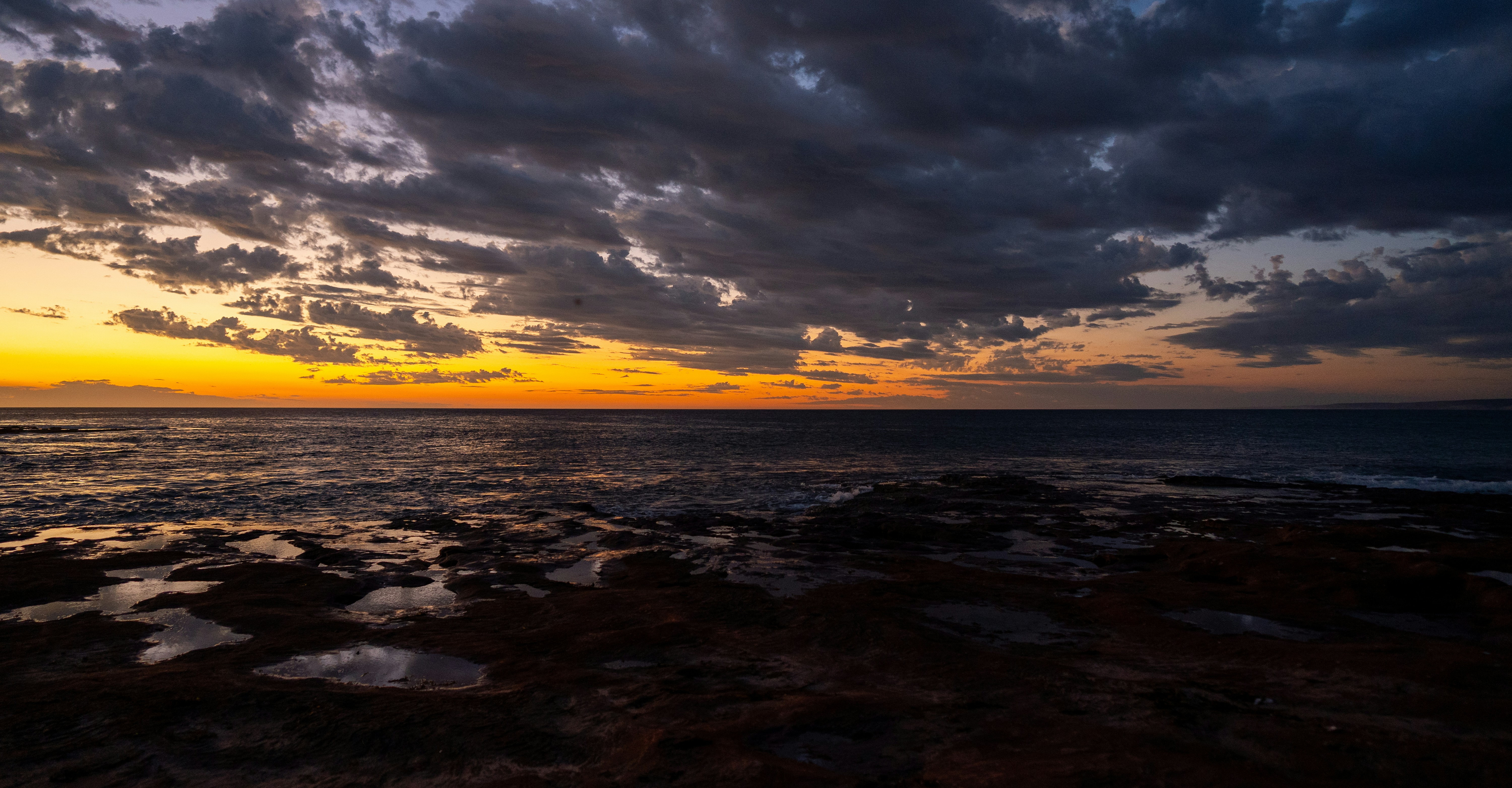 Horizon Glow Over Tidal Rocks at Dusk