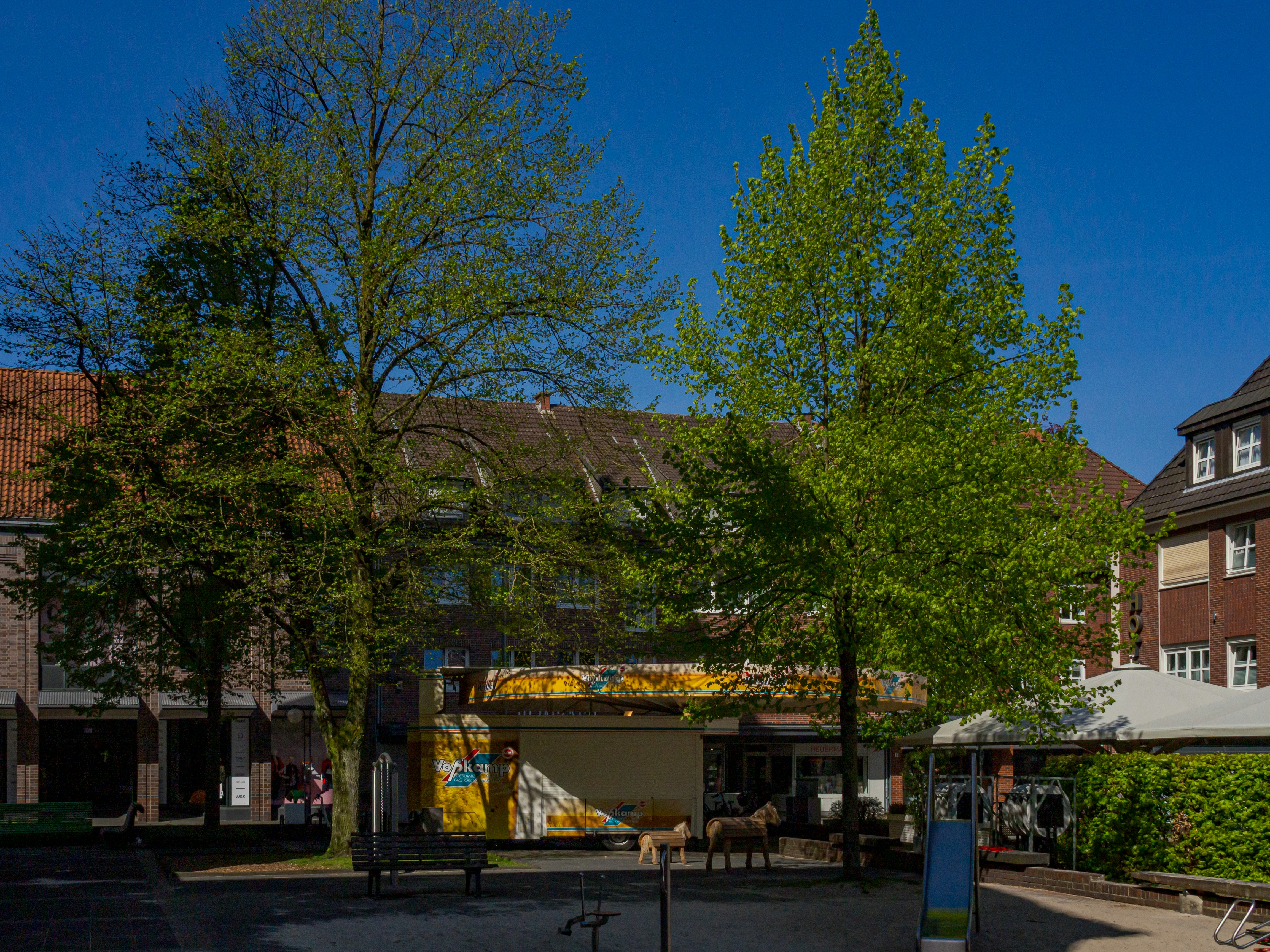 Sunlit Town Square: A Quiet Moment by the Food Stand