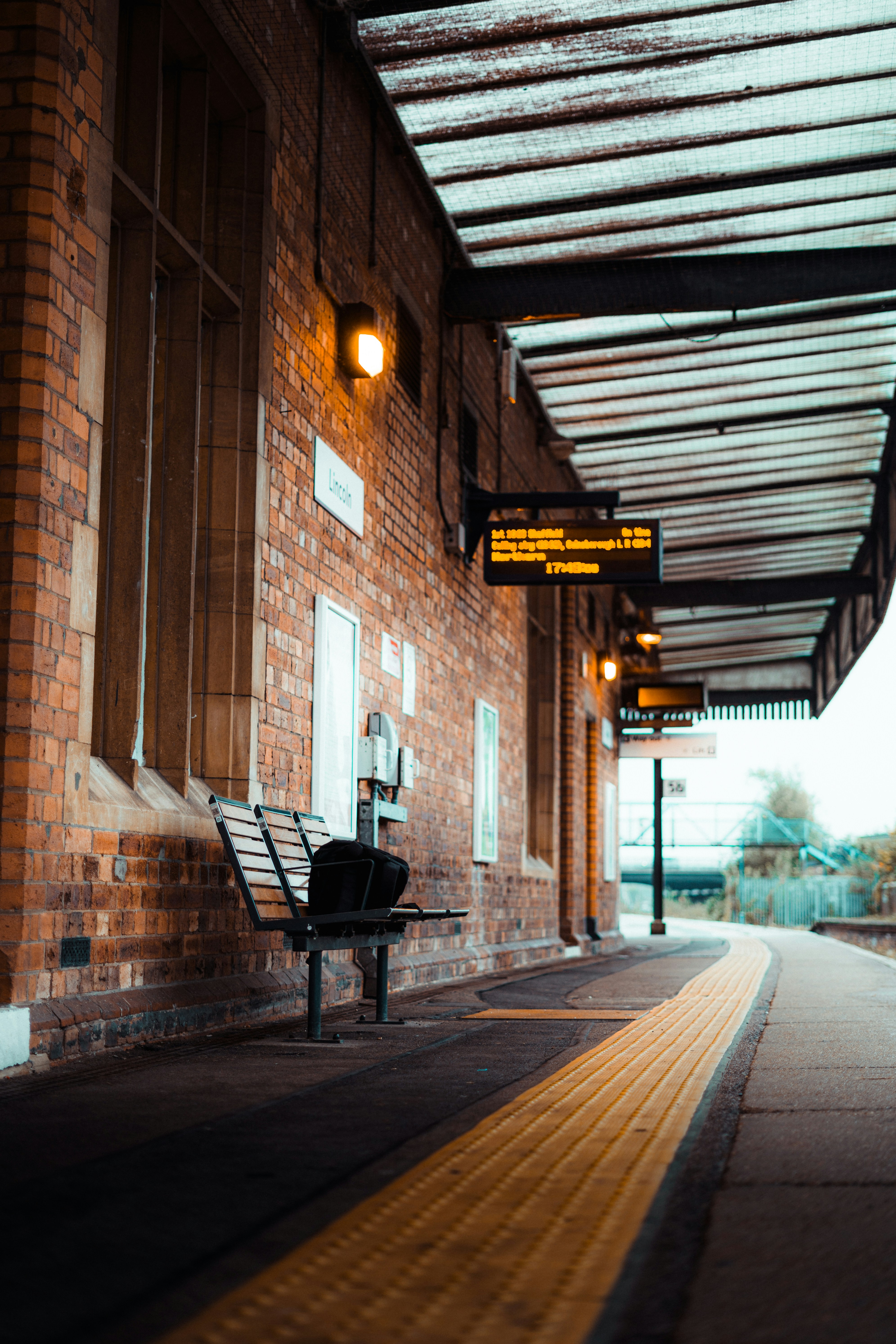 Quiet Platform Edge: Benches and Bricked Wall