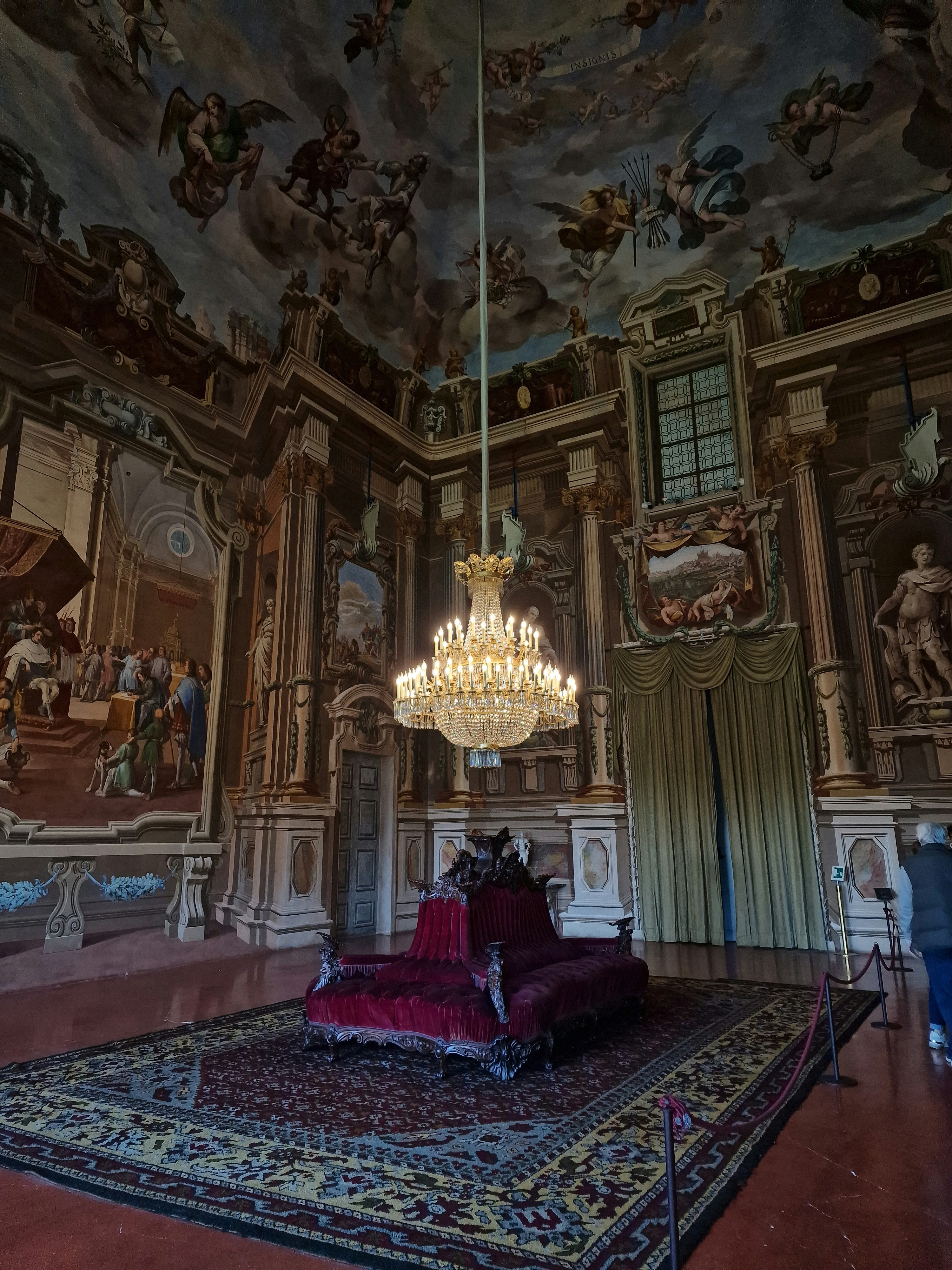 Chandelier Crowned Salon: A Baroque Hall Centered by Velvet Seating