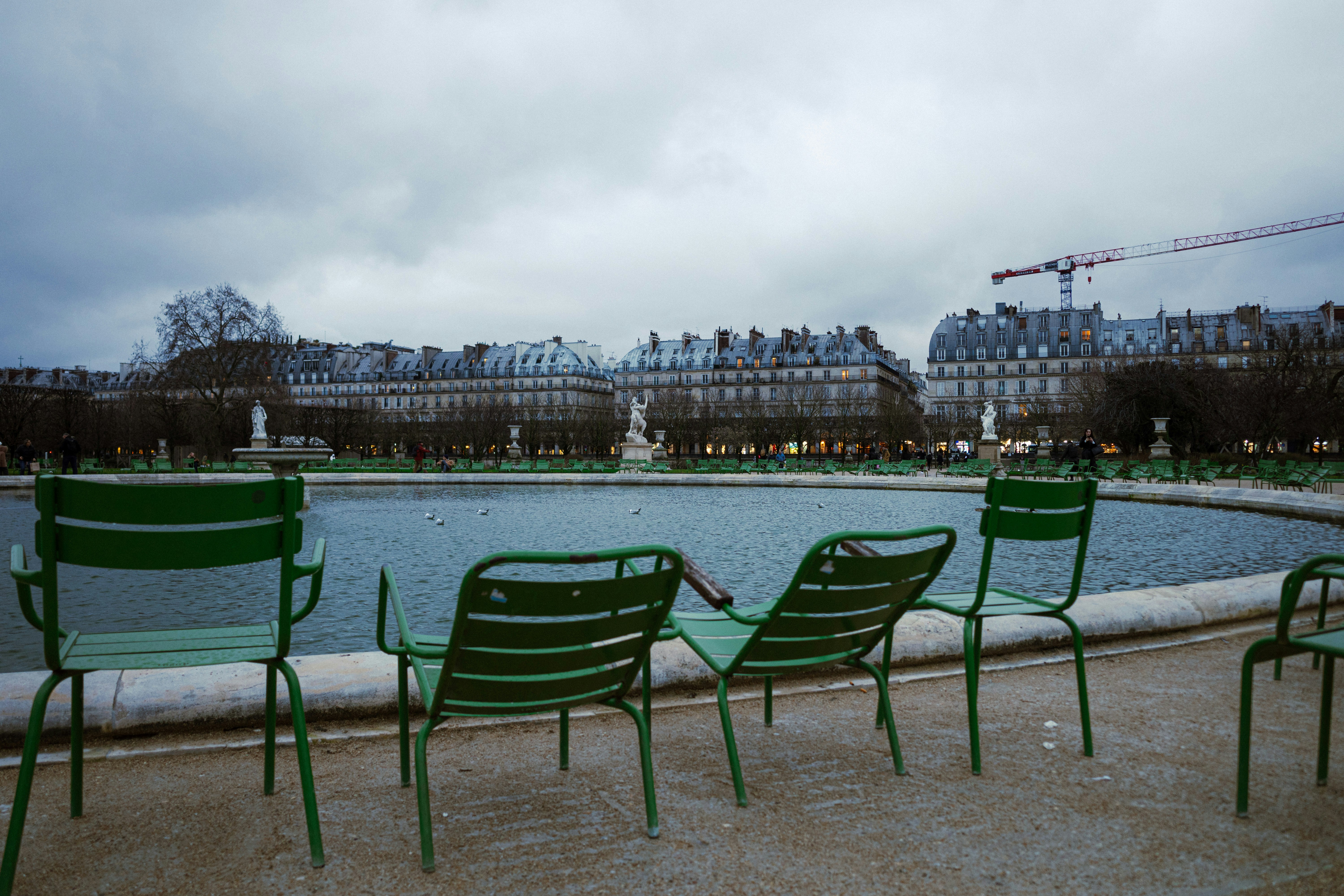 Green Chairs Overlooking a Serene Parisian Waterfront